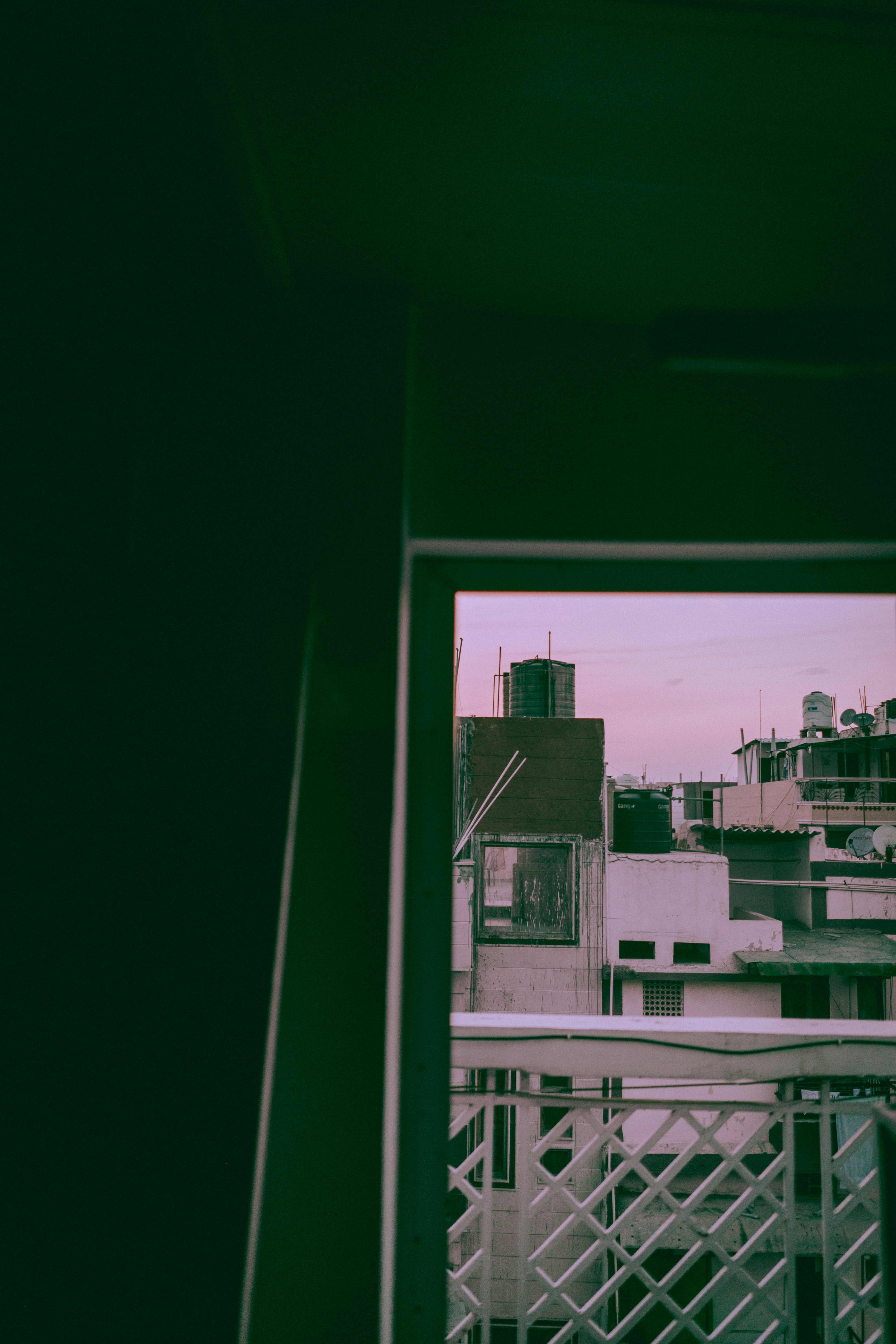 View of city rooftops framed by a doorway, capturing the essence of urban living. The soft color palette adds a serene atmosphere.
