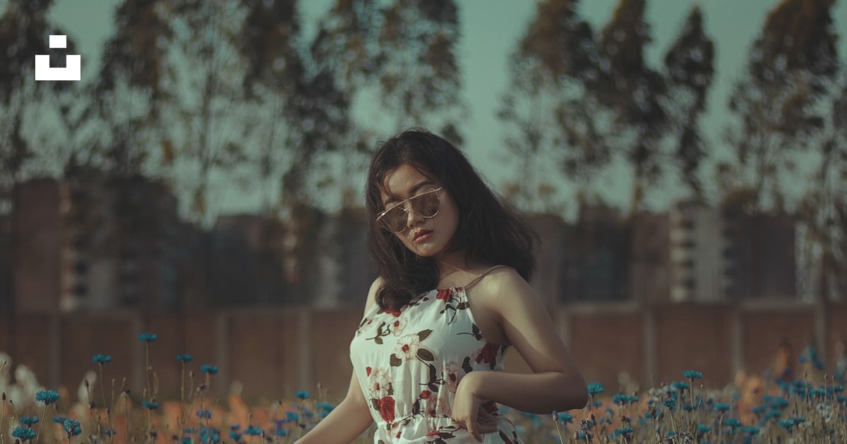 낮 동안 꽃밭에 서 있는 흰색과 파란색 꽃 드레스를 입은 여자 사진 Unsplash의 무료 사람의 이미지