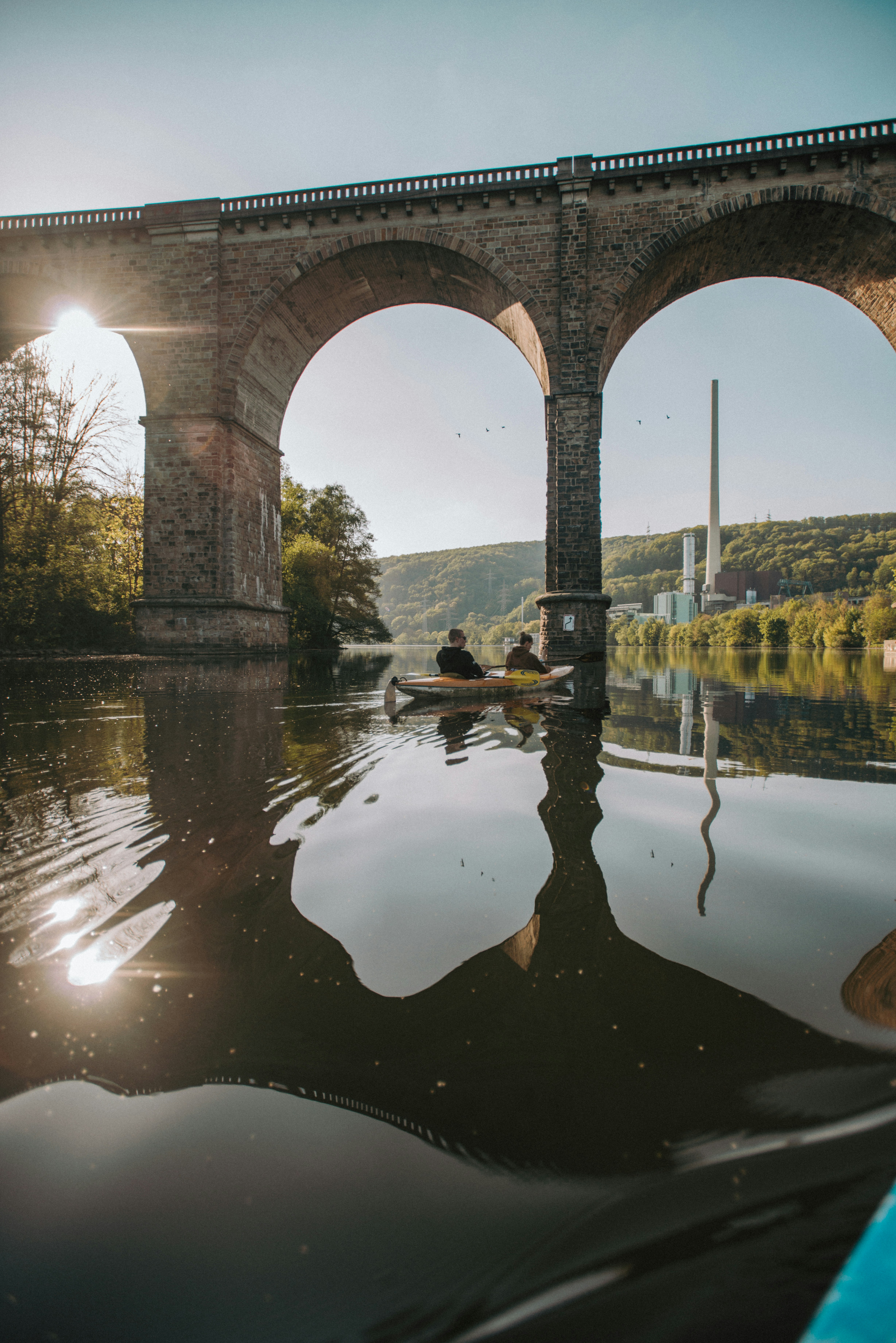 Sunlit Arc: Kayakers beneath a Bridge of Reflections