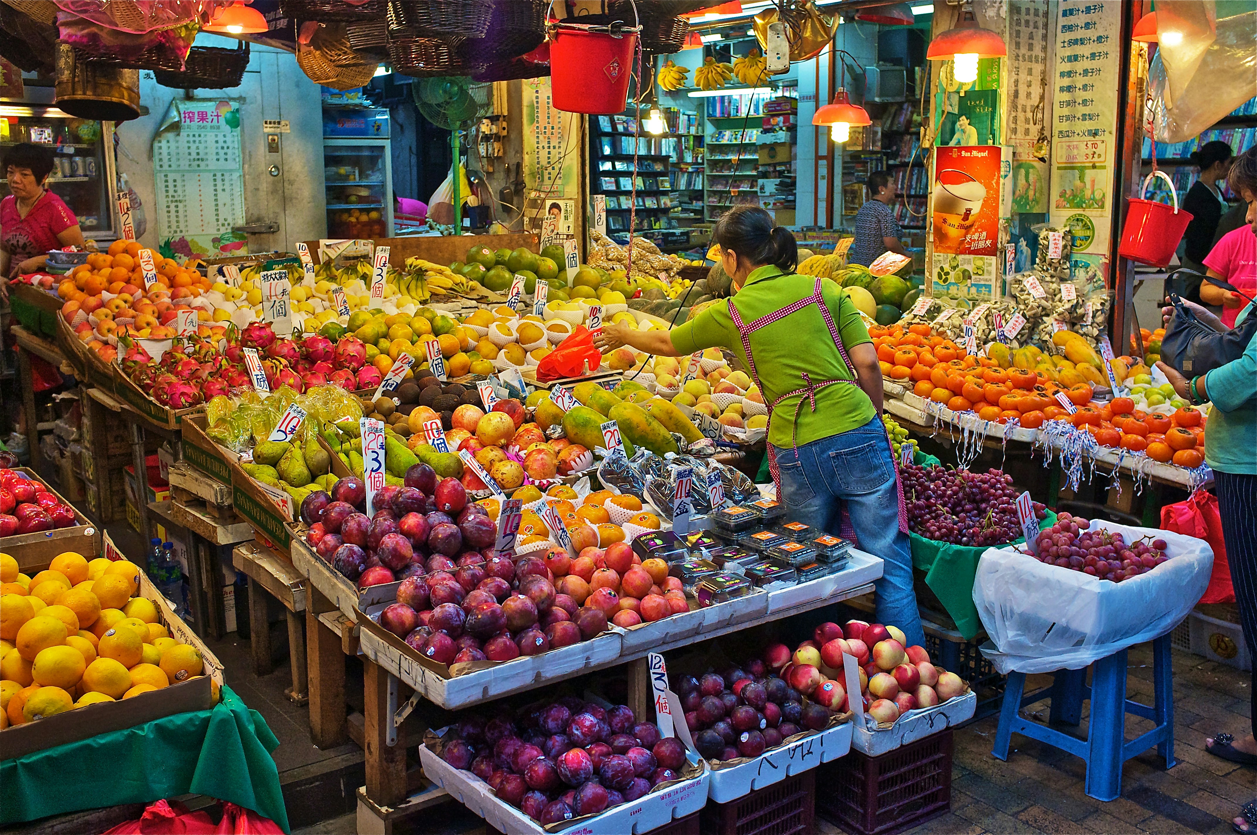A bustling fruit market filled with a variety of colorful fruits, showcasing the vibrant atmosphere of local commerce.