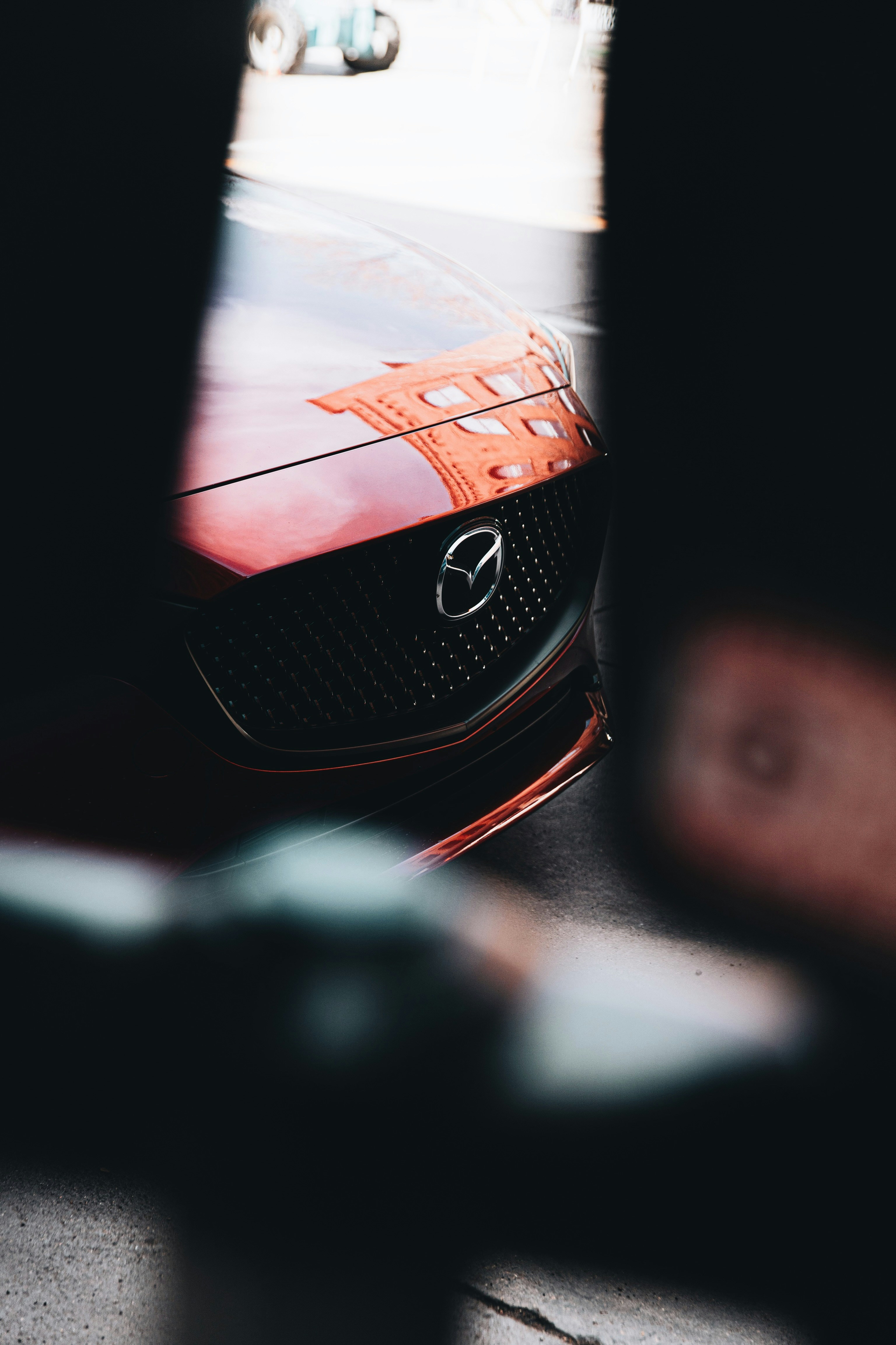 Frame Within a Frame: The Red Mercedes Hood and Emblem through a Narrow View