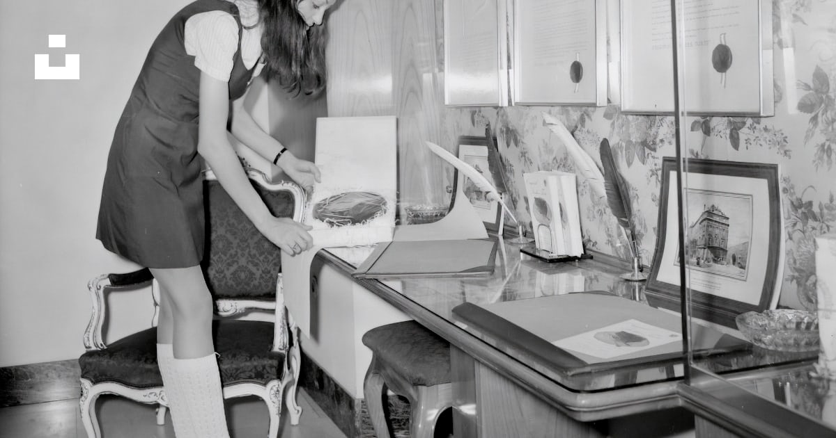 Woman In White T Shirt And Black Pants Standing Beside Table Photo