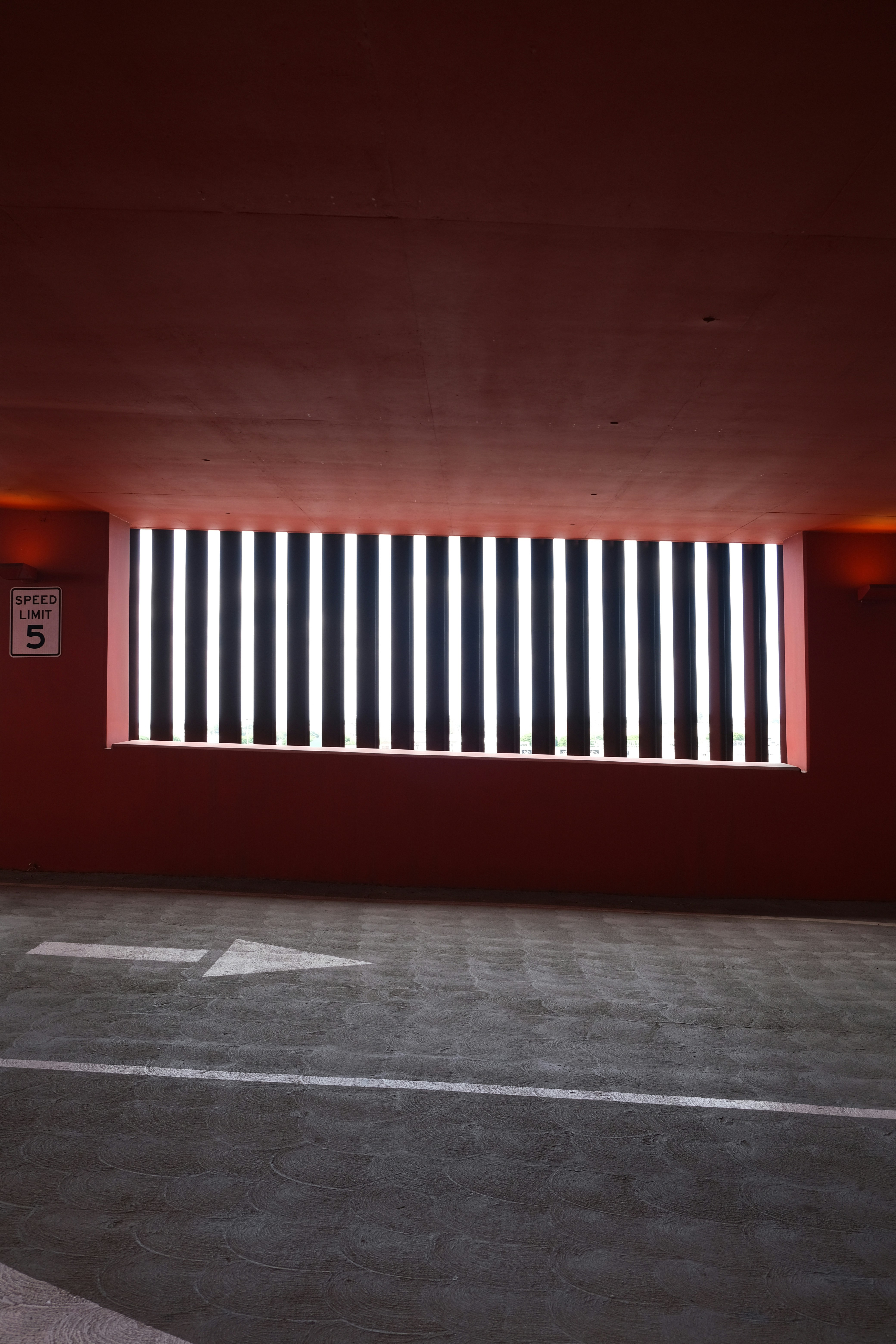 Crimson Parking Loft: Vertical Light Bars Framing a Quiet Exit