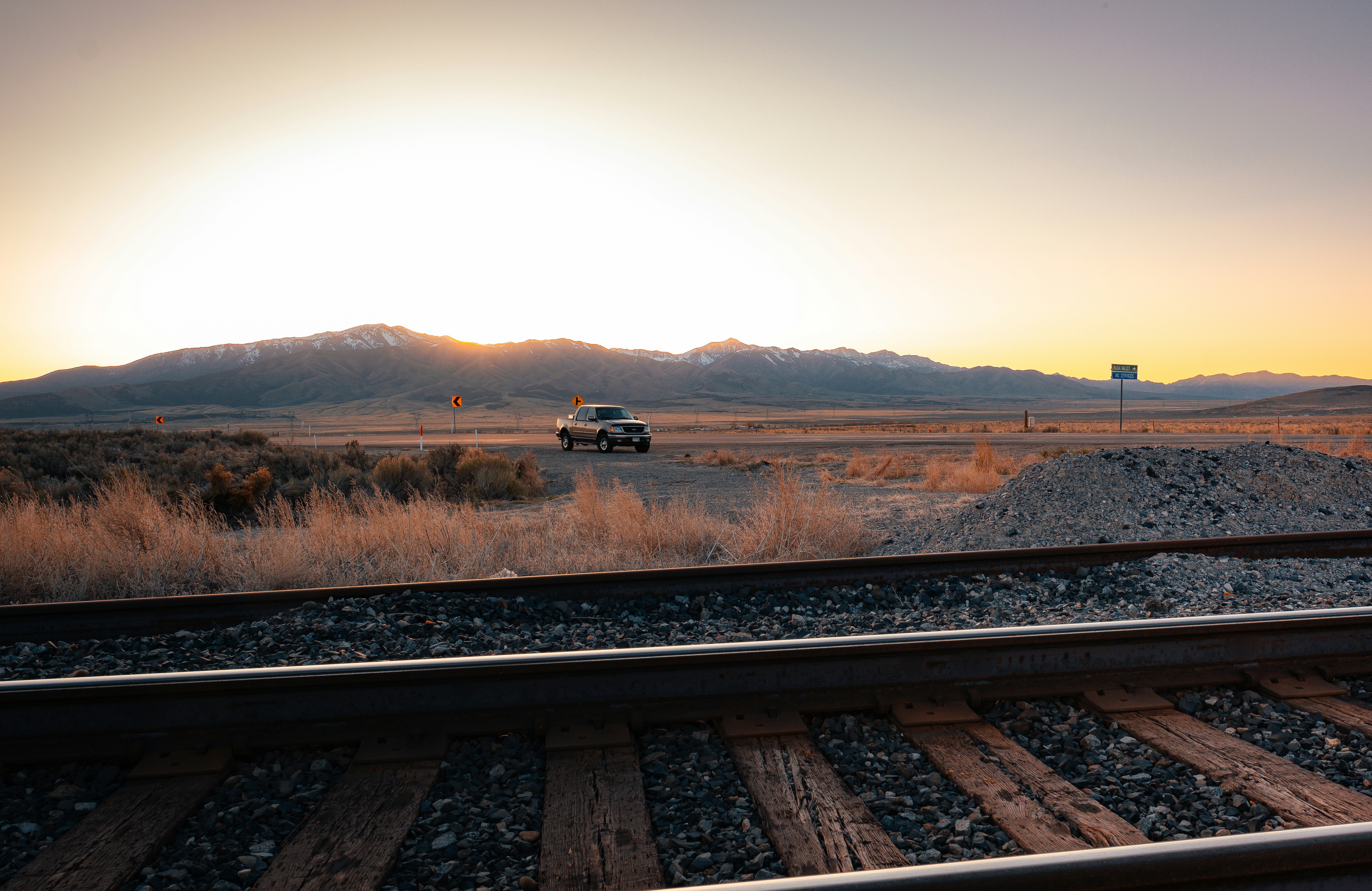 Desert Sunrise Over Rails: A Lone Car at the Edge of the Tracks