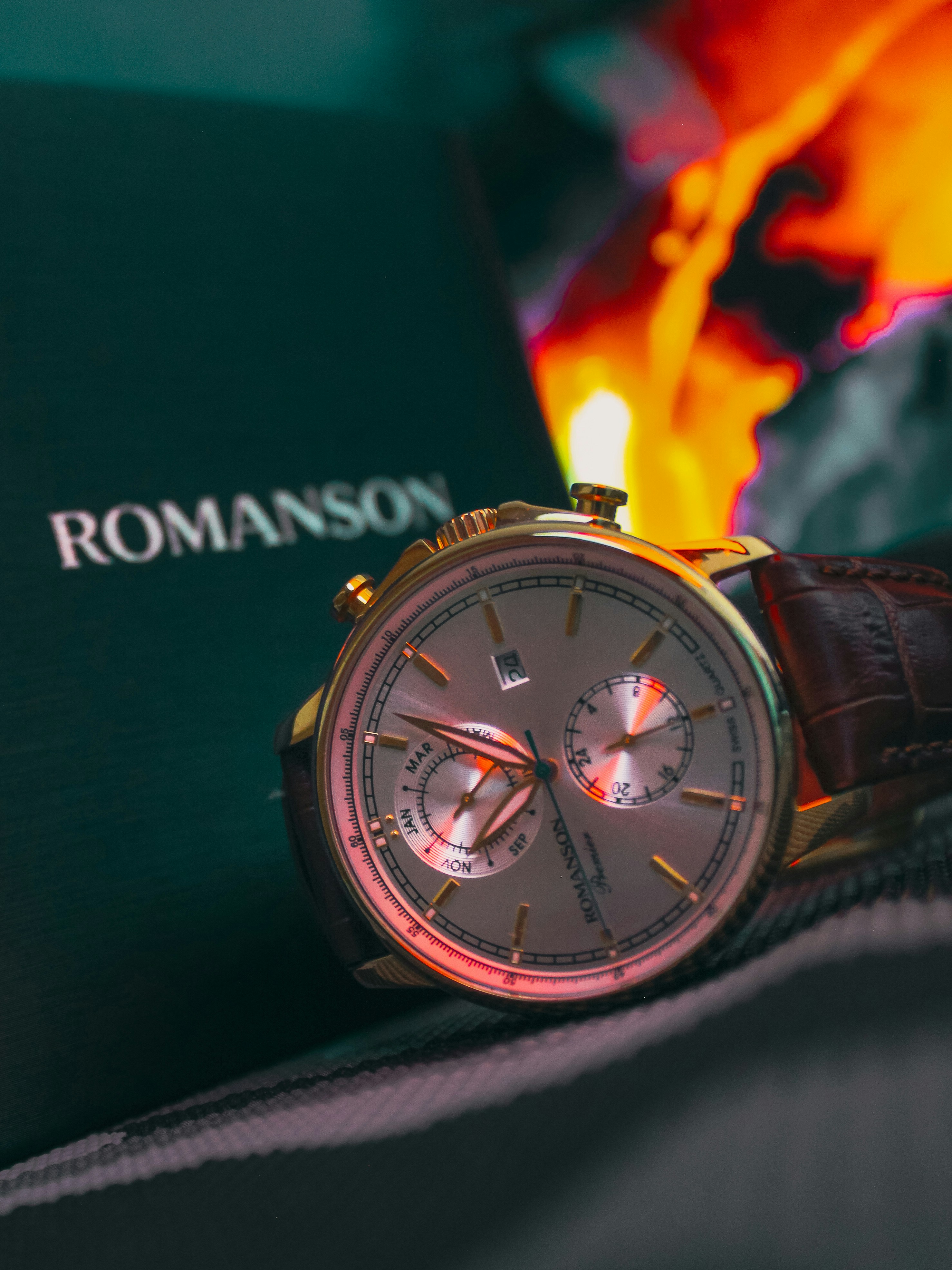 Gleam on the Dial: Romanson Watch Resting by a Green Box