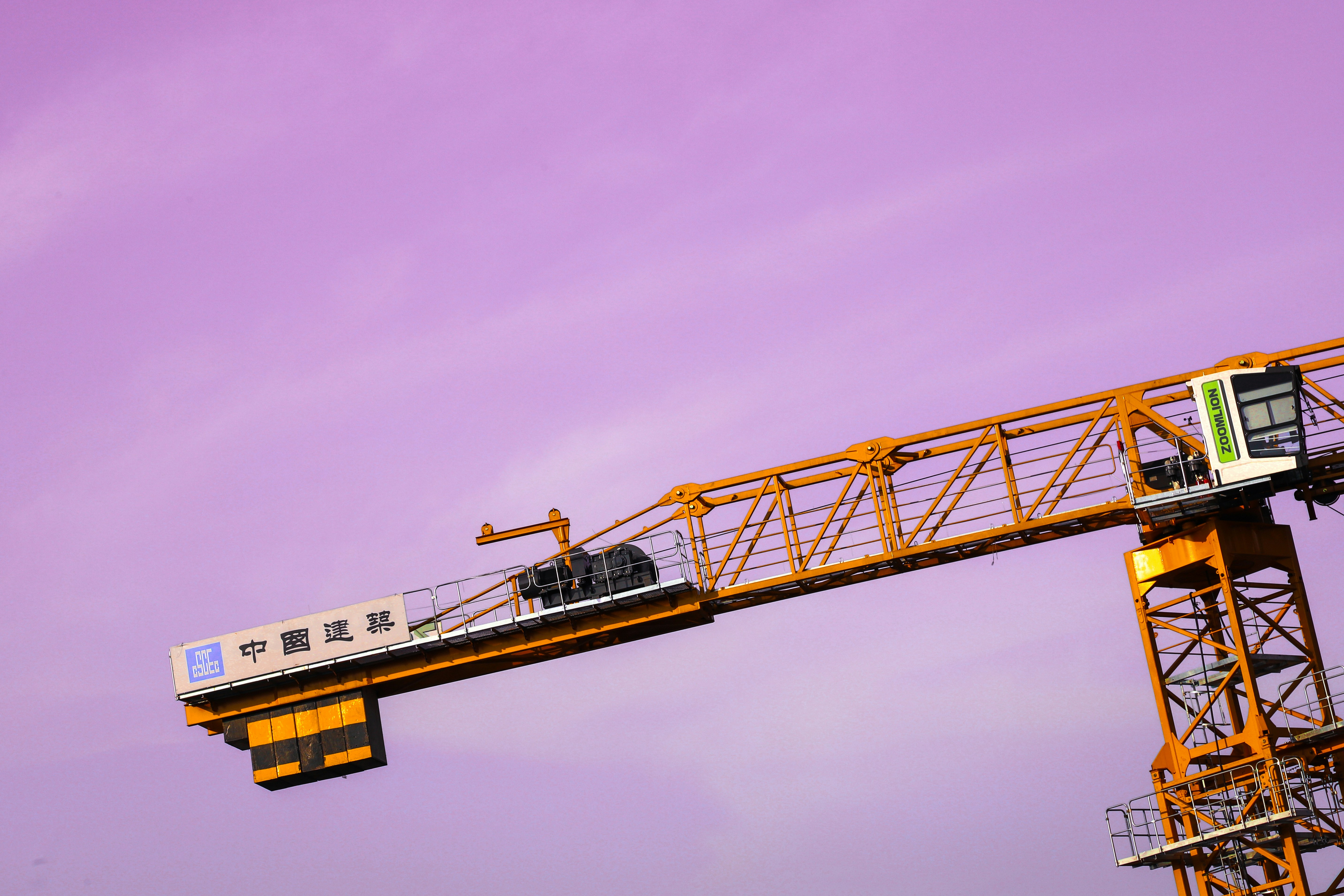 Crane Against Lavender Sky: An Orange Arm Crowned by Steel