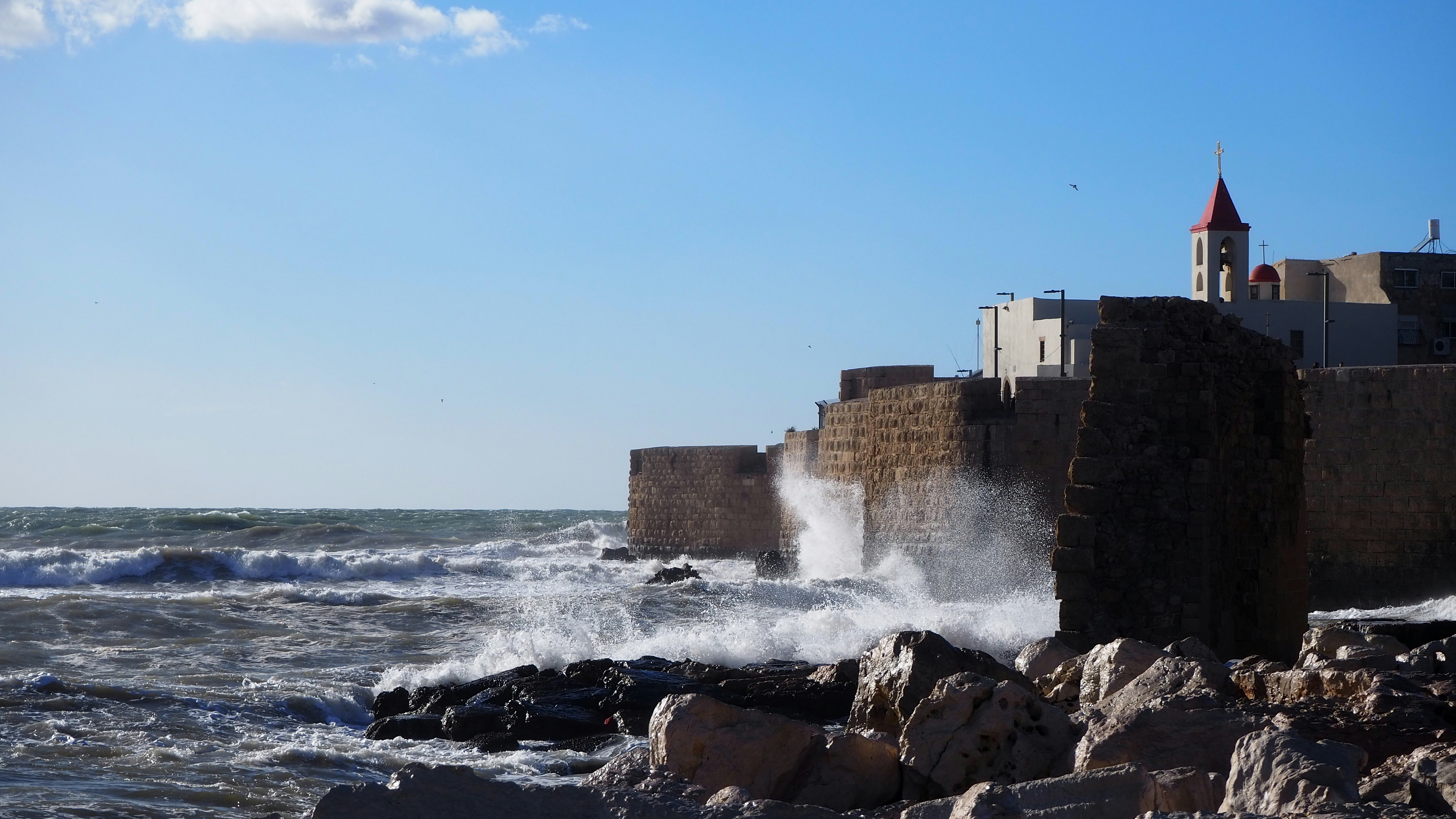 brown concrete building near sea during daytime