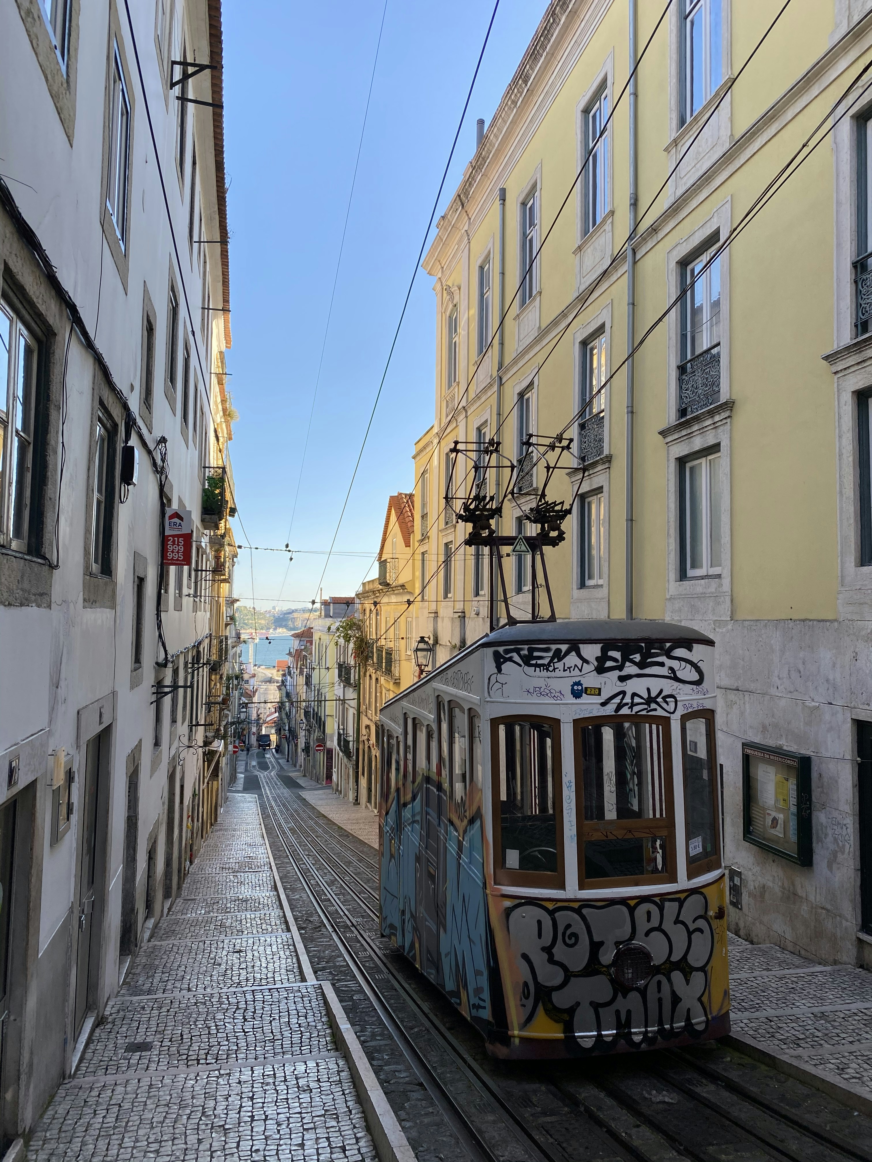 Graffiti-Tagged Tram Races Down a Sunlit European Slope