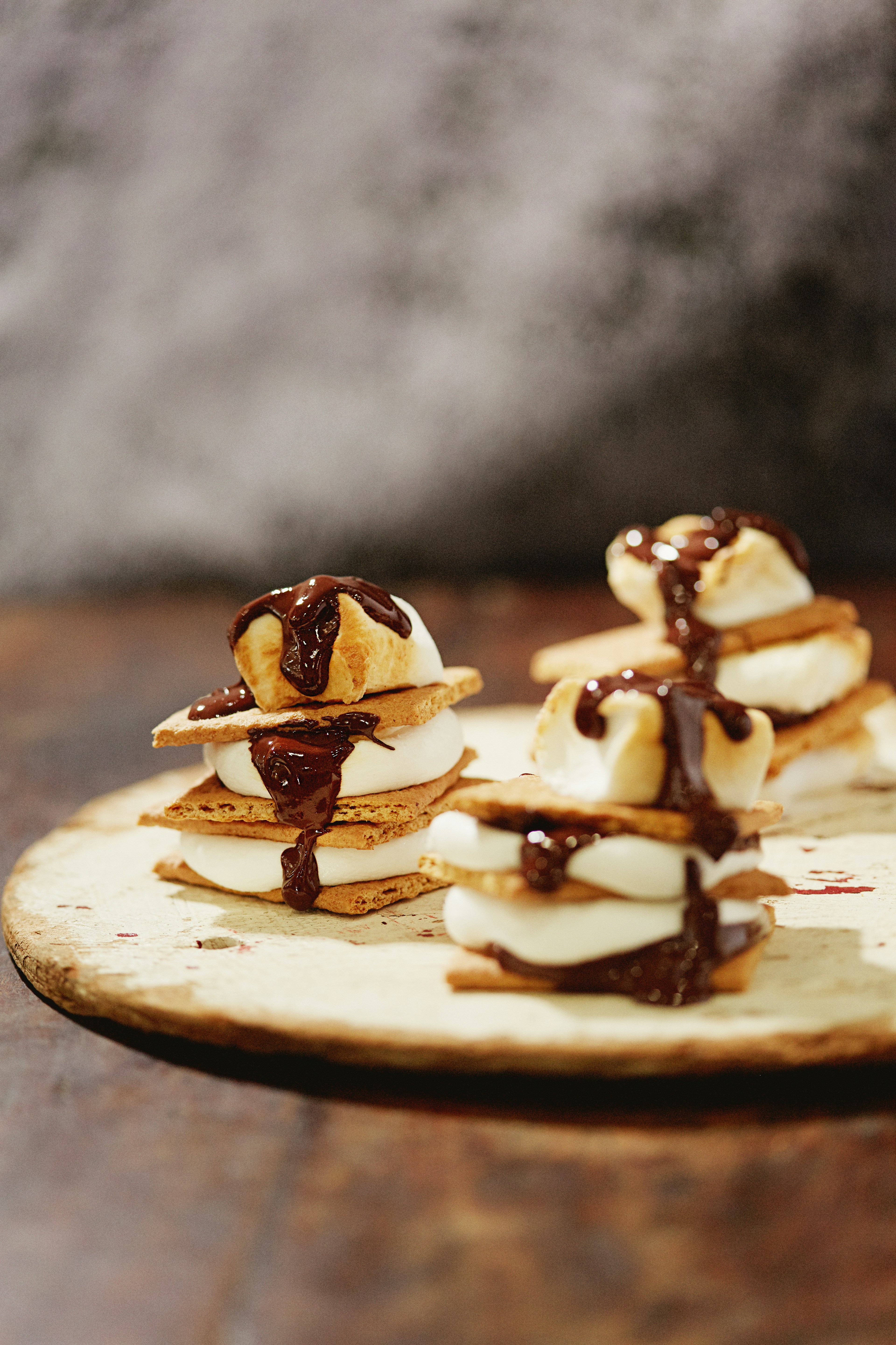 Petite Dessert Towers: Cream, Cookies, and Chocolate Drizzle on a Rustic Plate