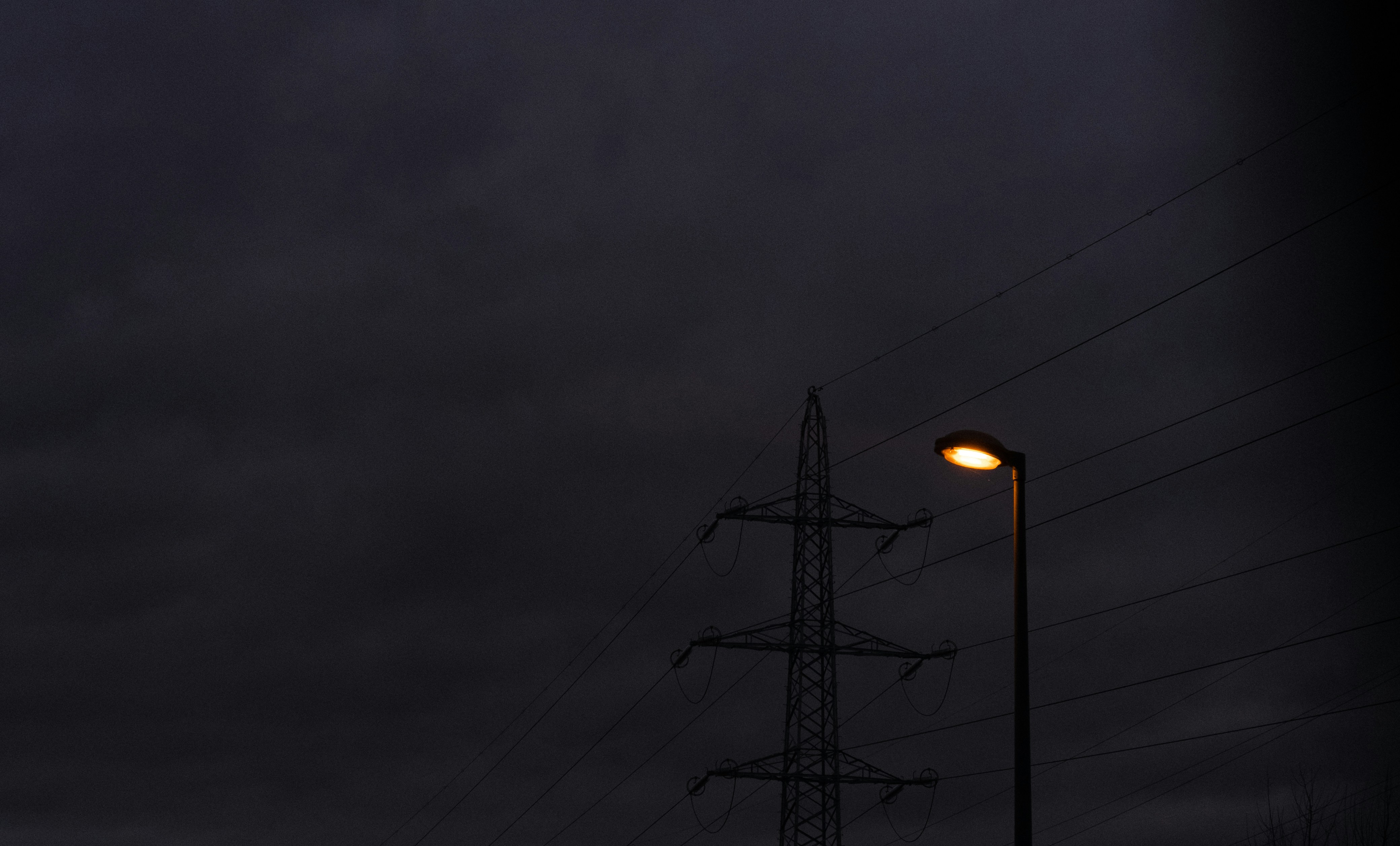 black electric post under gray sky