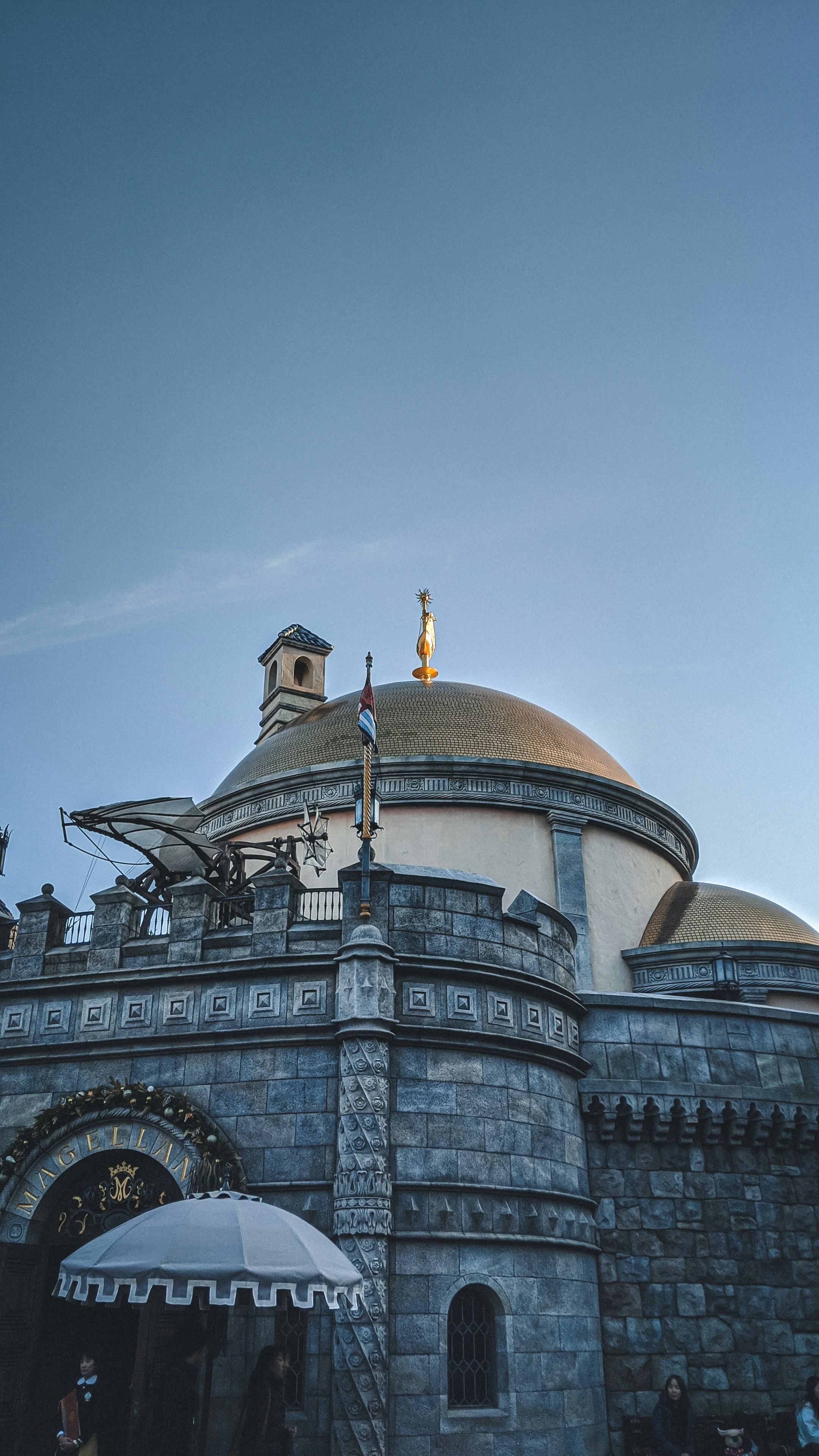 Stone building with a golden dome under a clear blue sky.