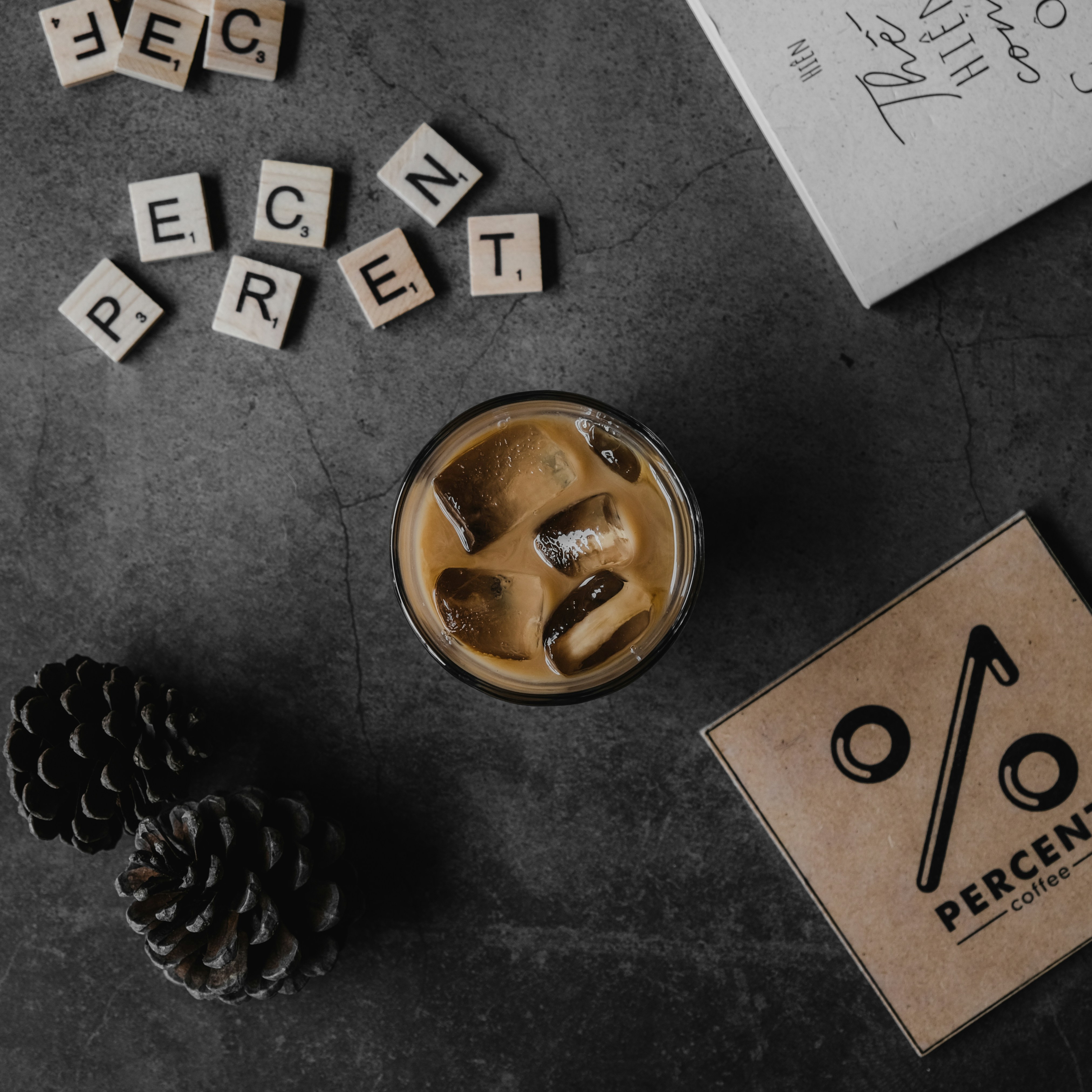 Iced Coffee, Pine Cone, and Scrabble: a Quiet Studio Still Life