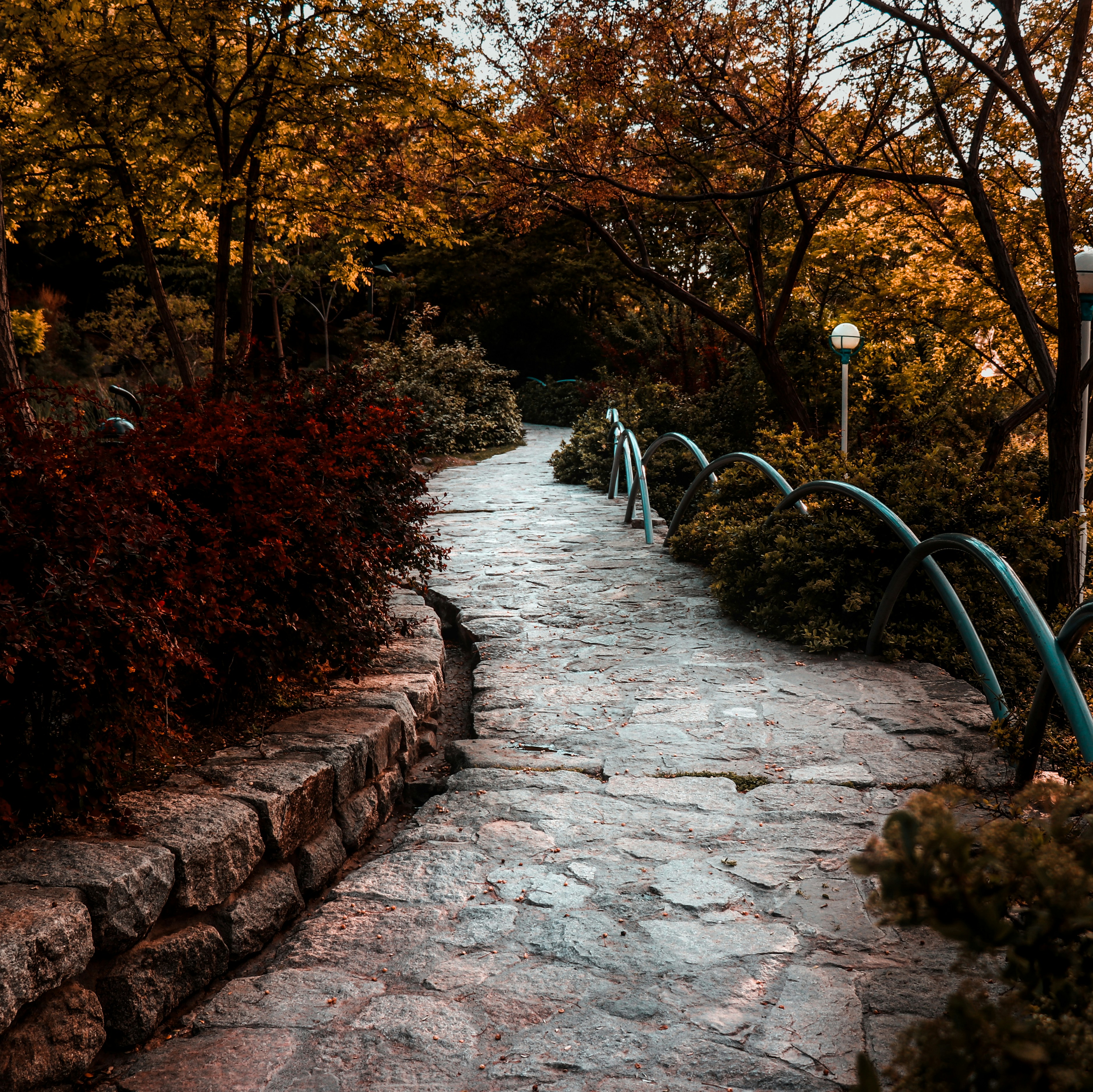 Autumn Corridor: A Winding Stone Path Toward Quiet Dusk