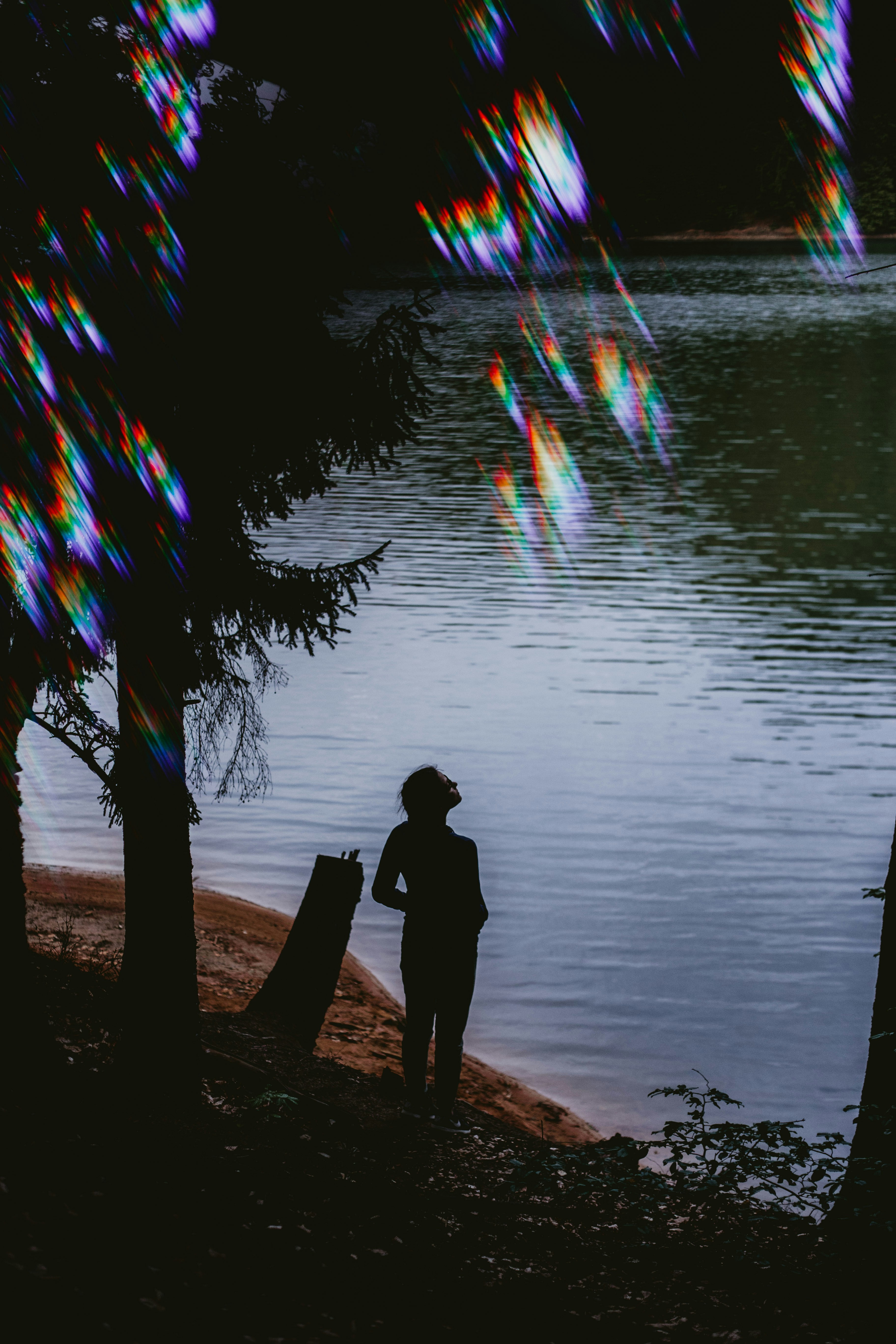 Silhouette by the Shore: A Quiet Moment Framed by Rainbow Fragments