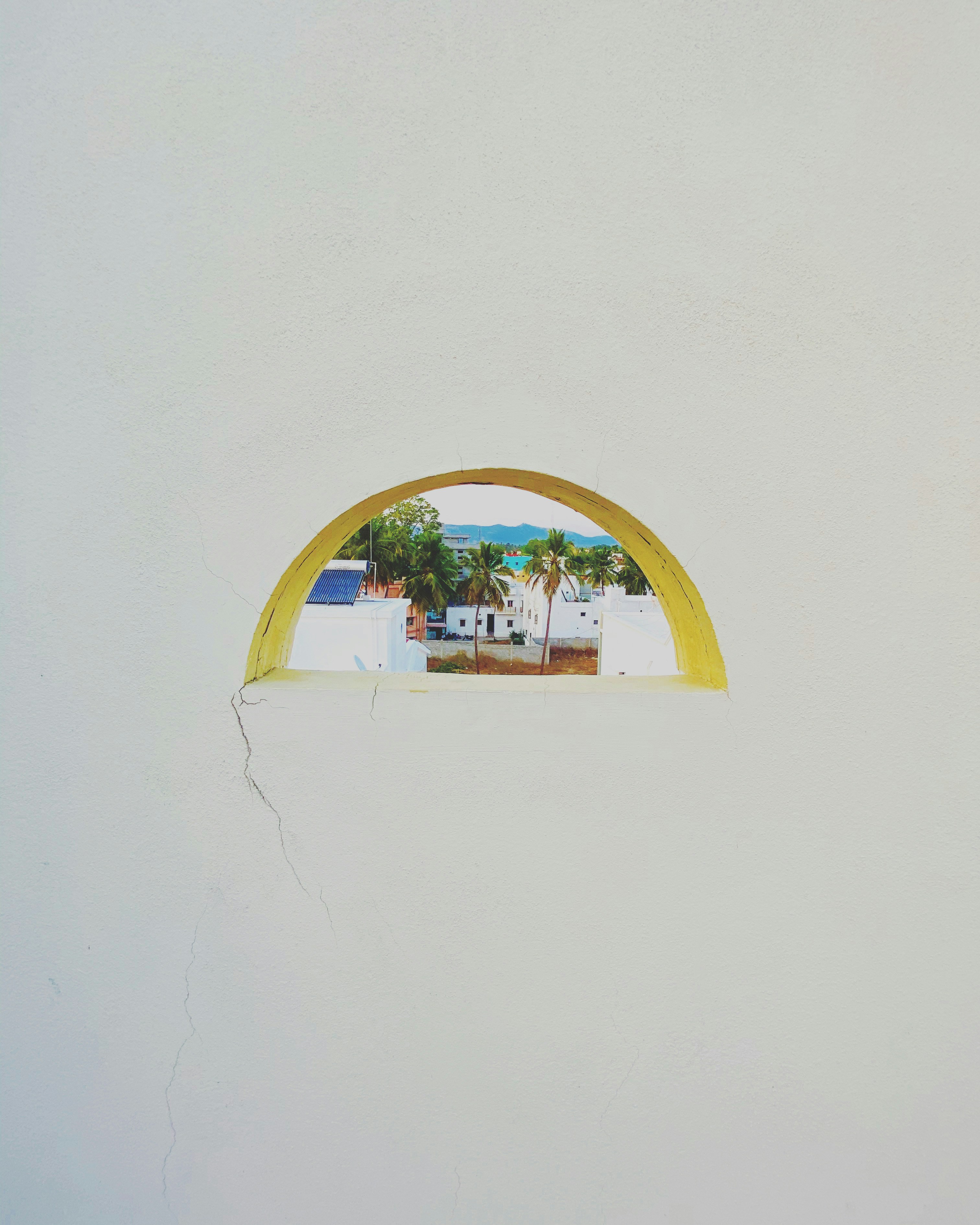 A Palm-Front Village Through a Circular Yellow Arch