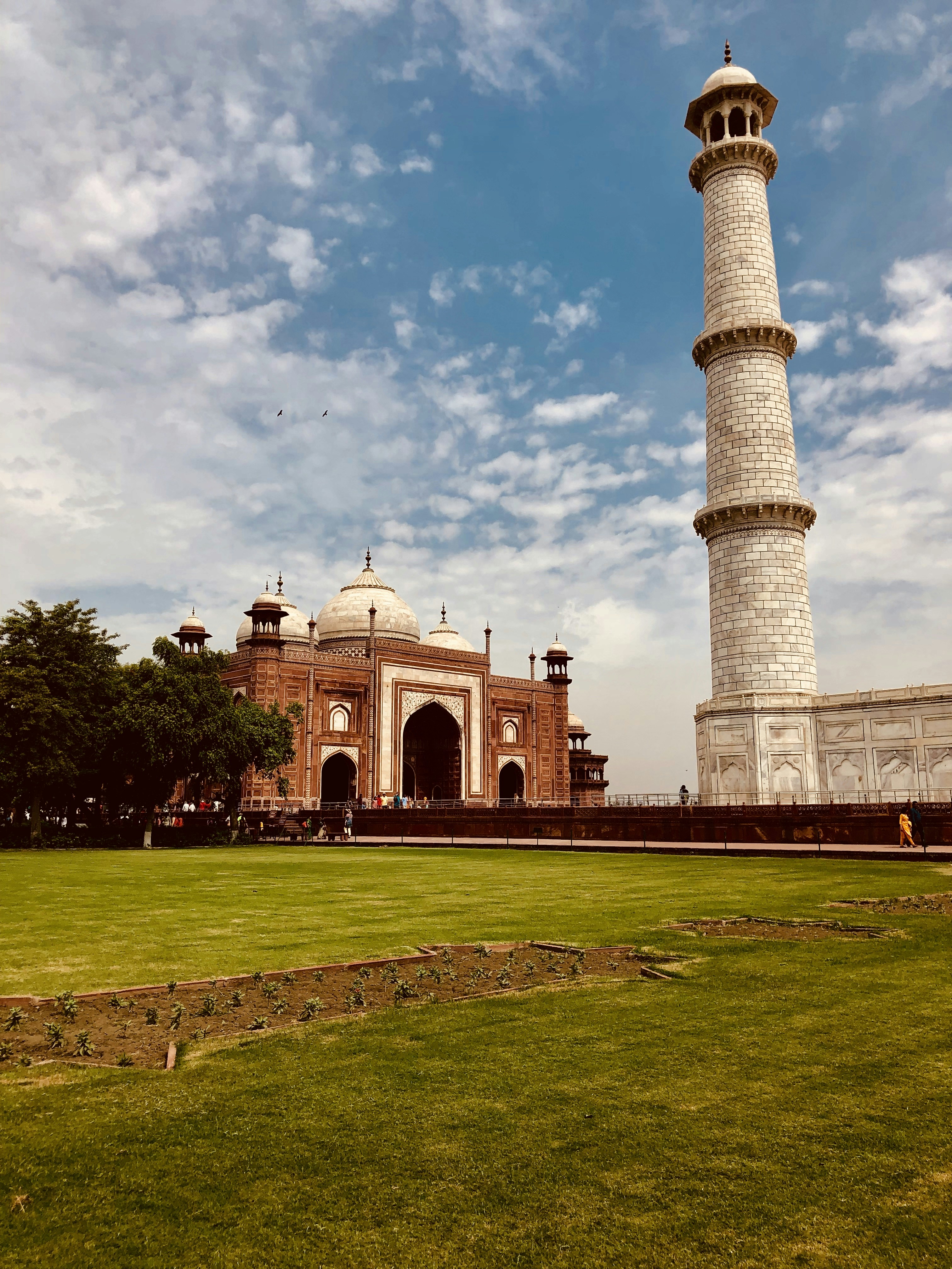 Crimson Gateway Framed by Marble Minaret under a Vast Blue Sky
