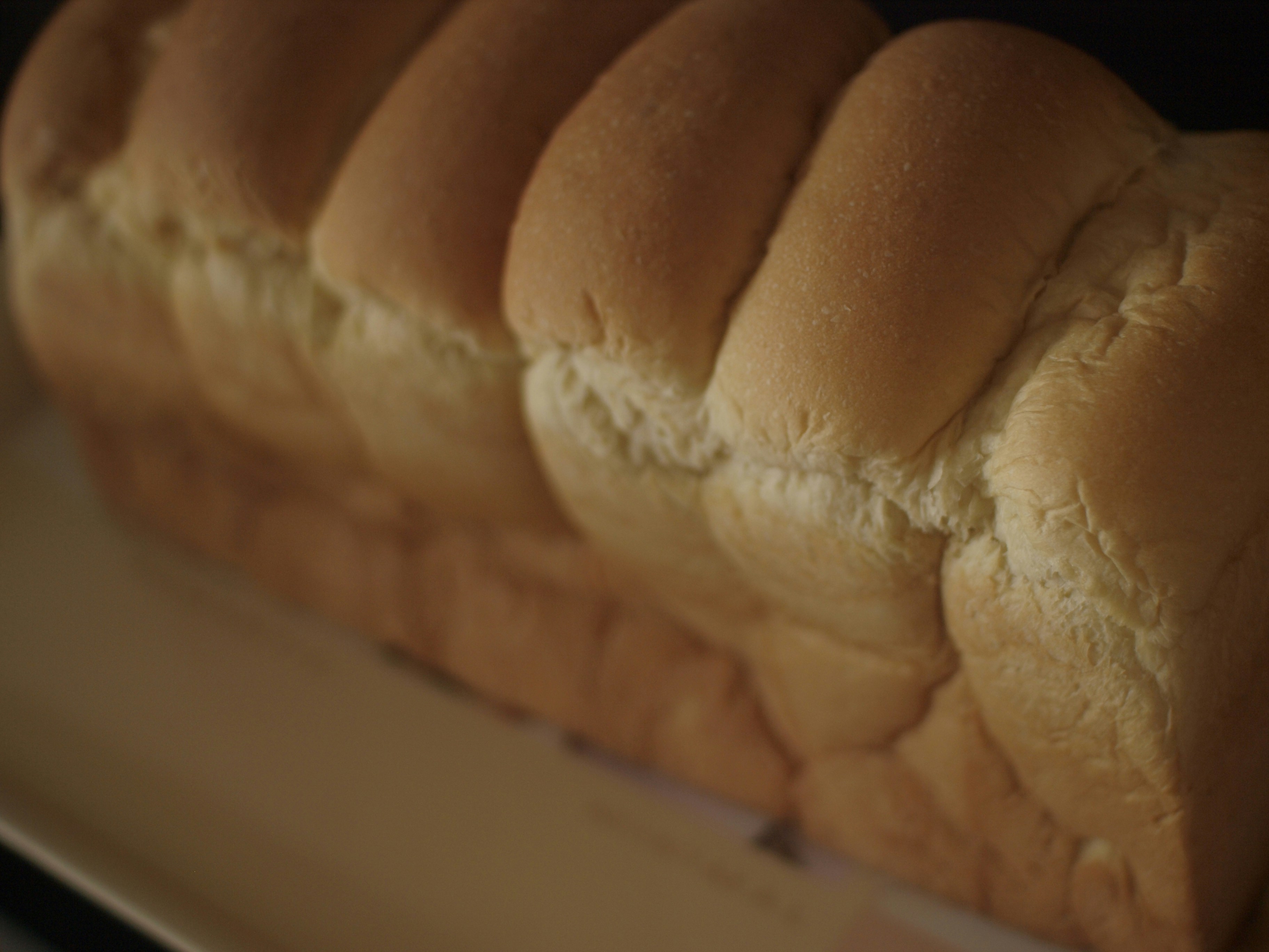 Freshly baked loaf of bread with a golden crust, showcasing its soft texture and inviting appearance.