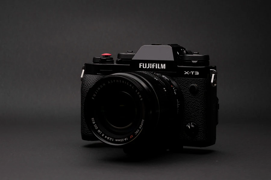 A Fujifilm X-T3 camera with lens attached sits against a smooth dark backdrop, lit with dramatic low-key lighting. The body and lens details stand out with subtle reflections.