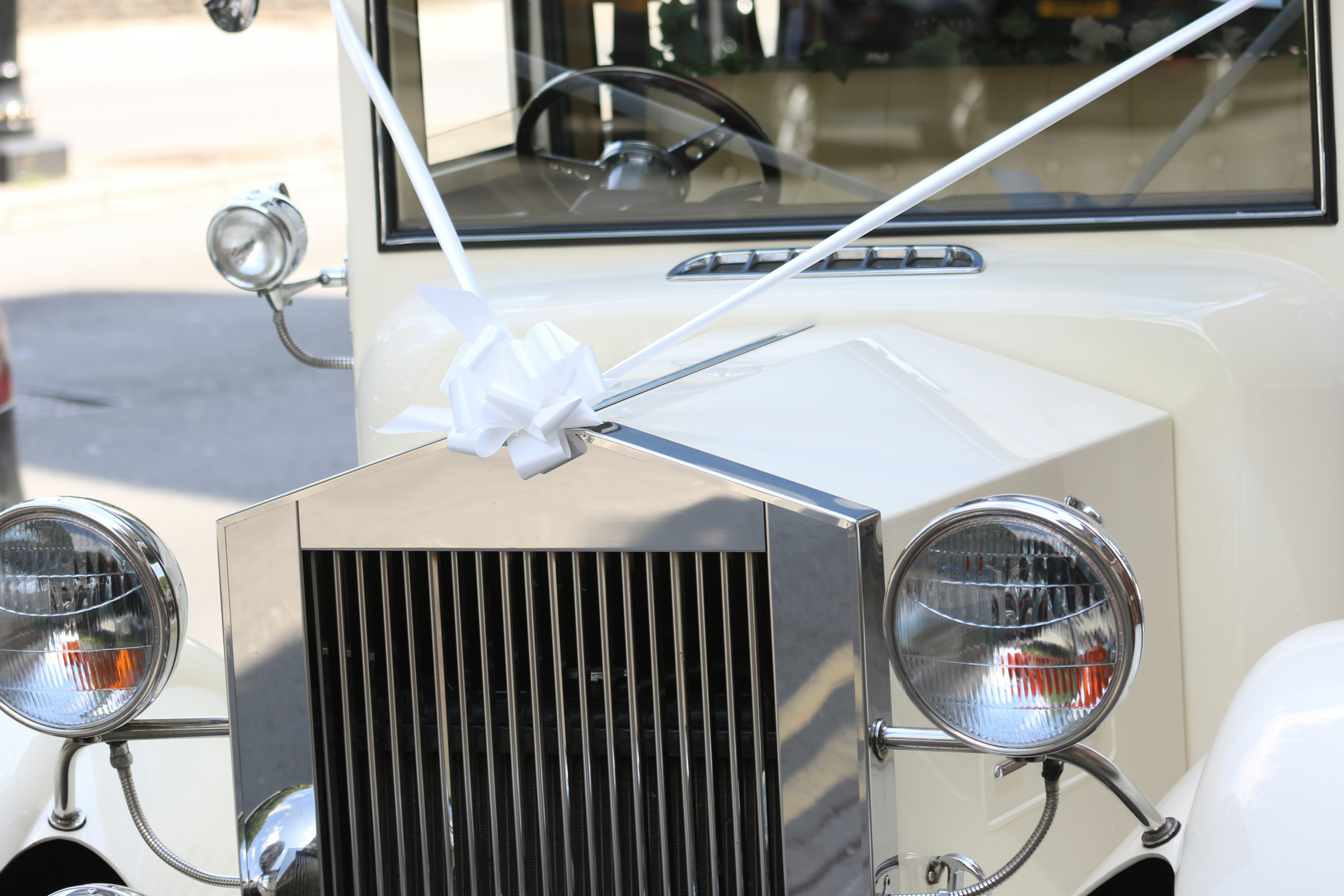 Ribboned Heritage: The Front Grille of a Vintage White Car