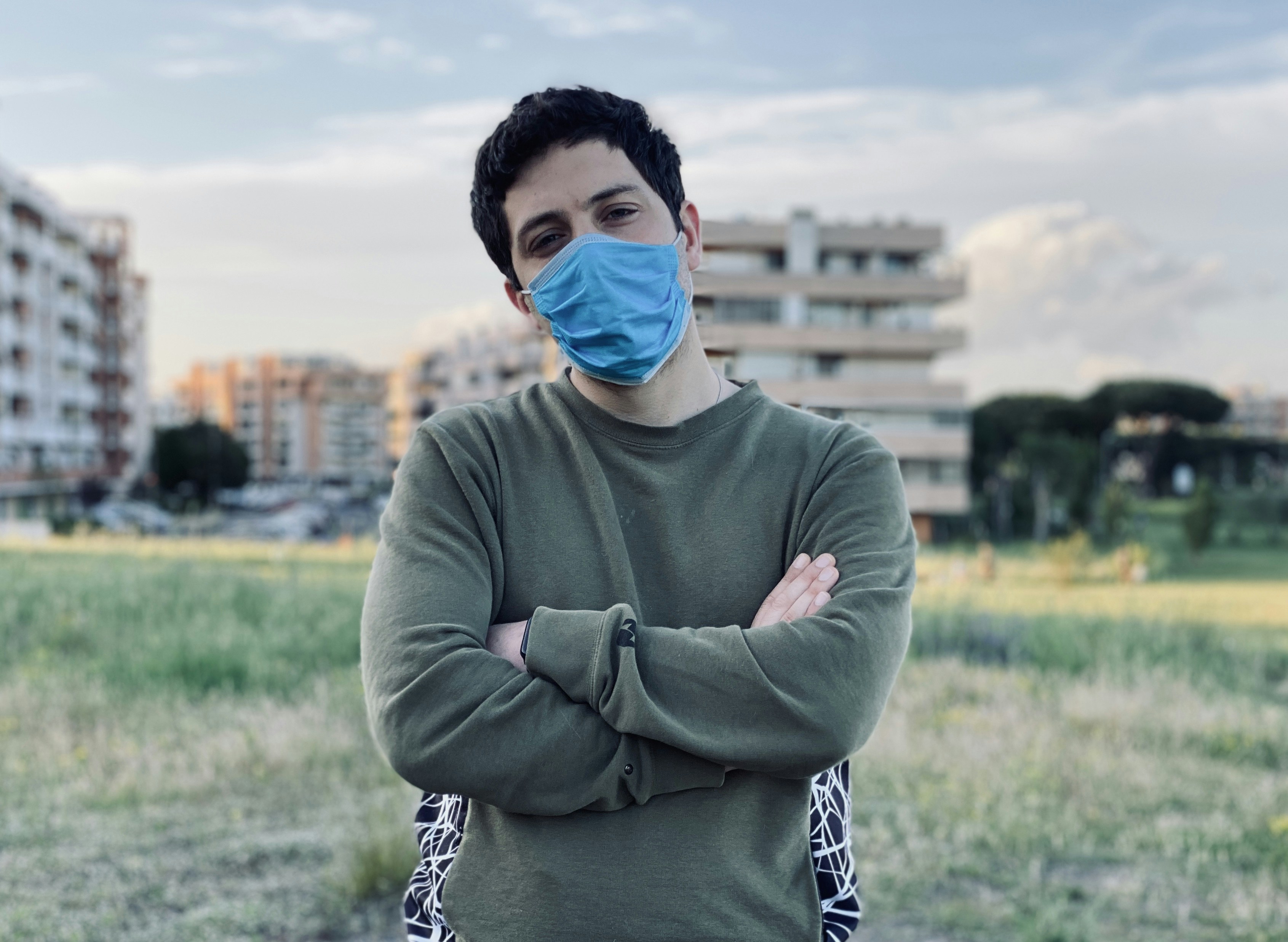 Crossed Arms, Quiet Confidence: A Masked Portrait in an Open Field