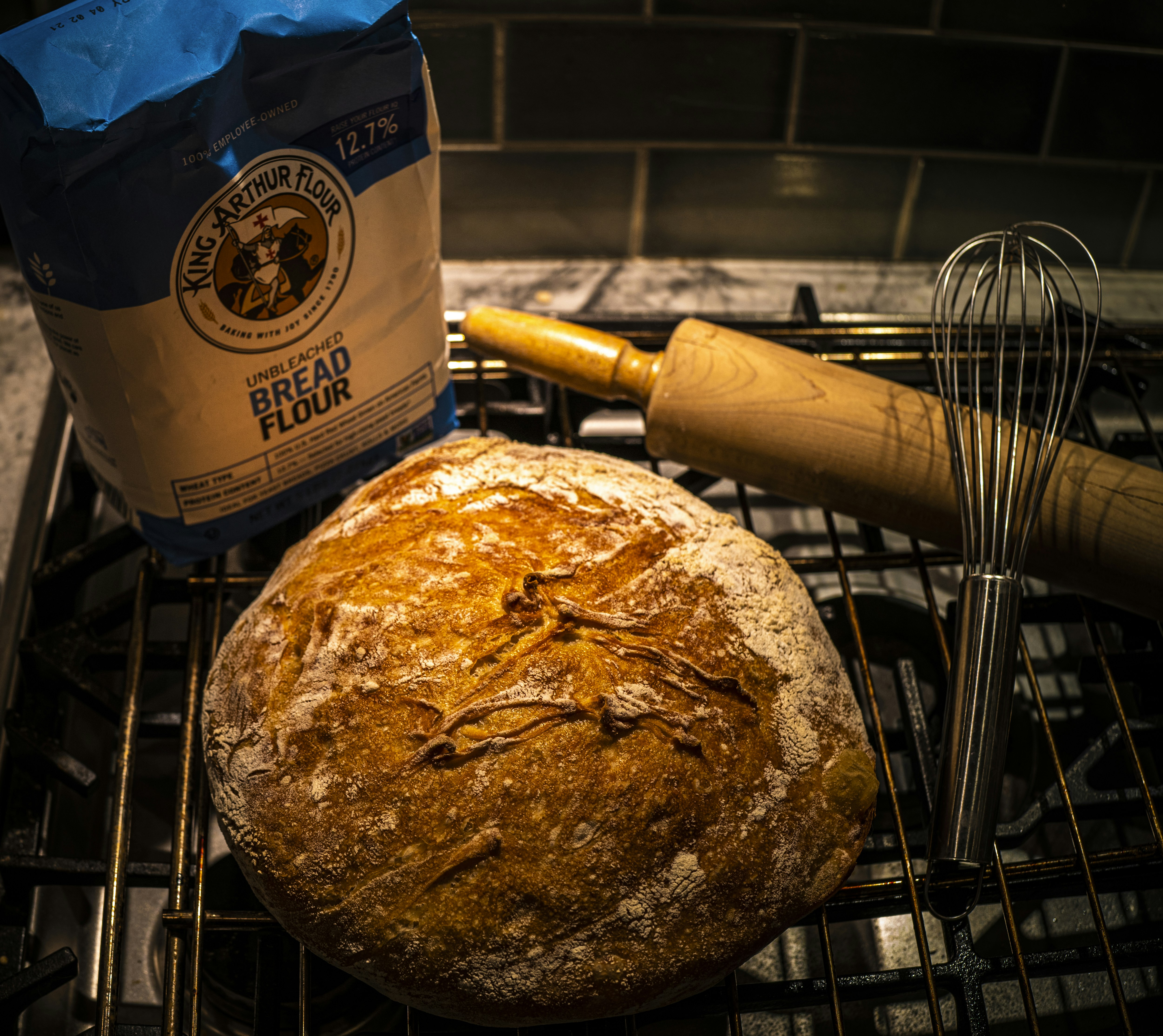Crust at Rest: Artisan loaf cooling beside flour and kitchen tools