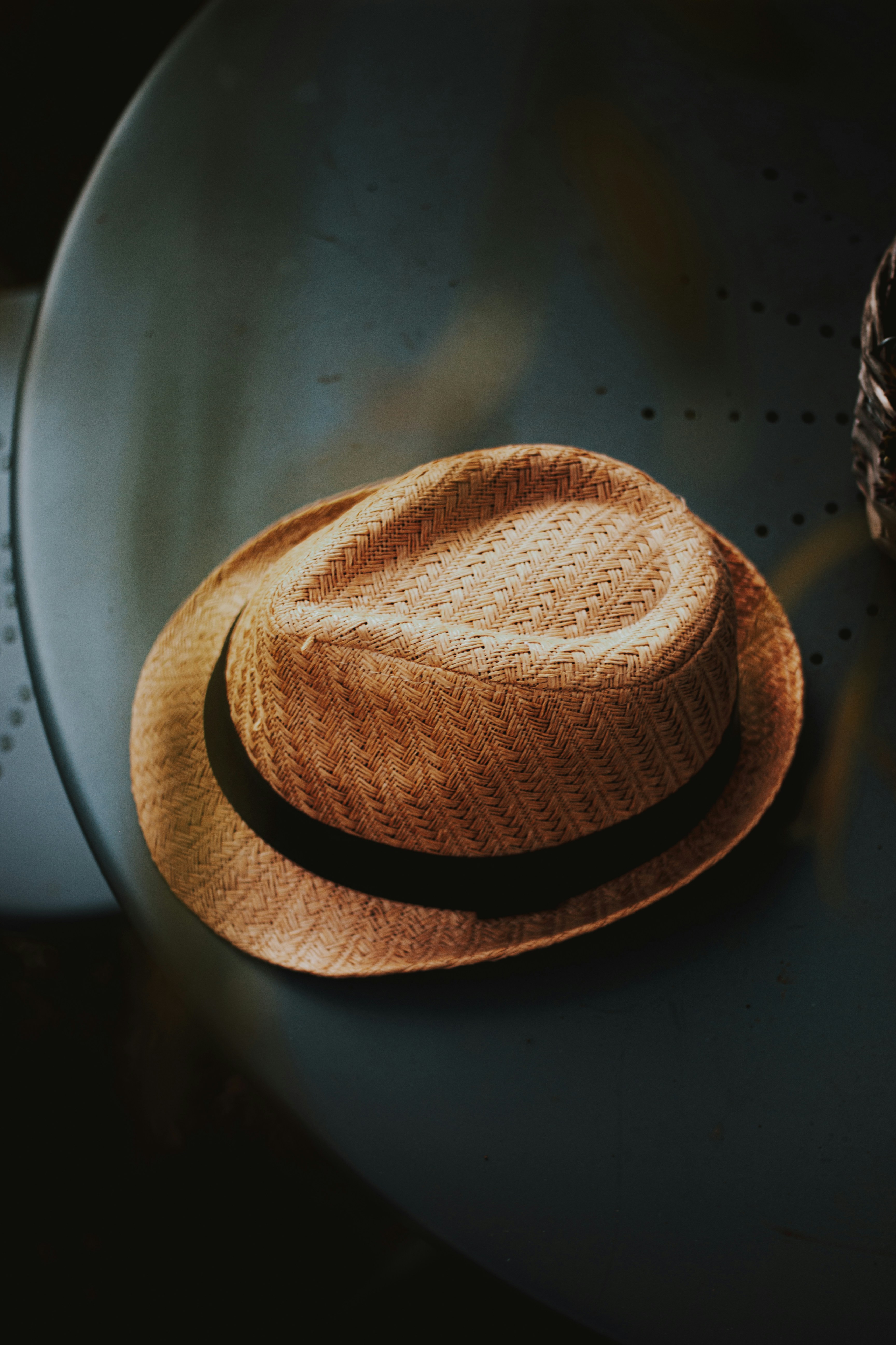 Stylish straw hat resting on a round blue table, capturing a serene moment of leisure.