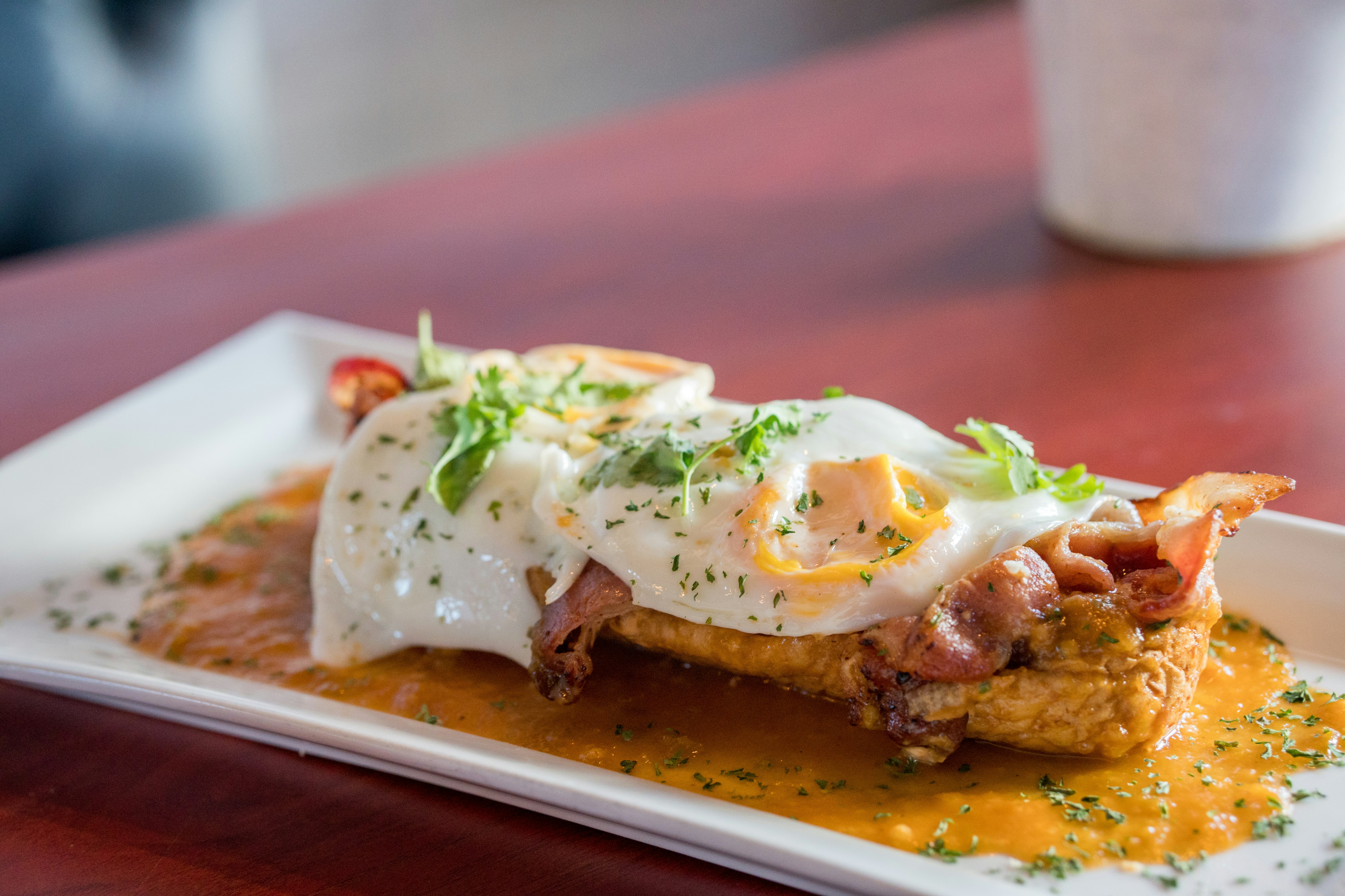 Poached-Egg Crown on Crispy Pork with Herb-Infused Orange Sauce