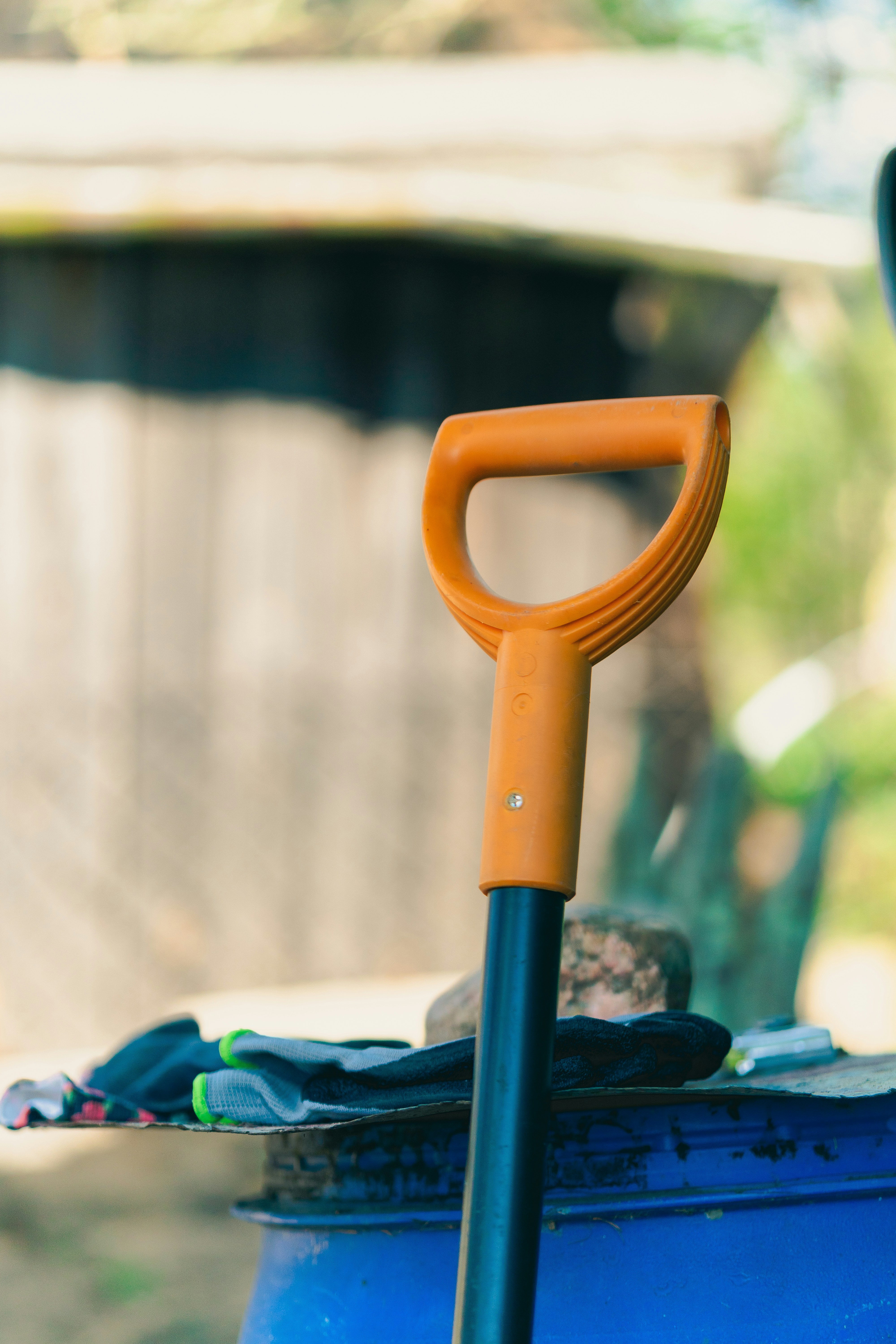 Shovel Cresting From a Blue Bin Under Soft Outdoor Blur