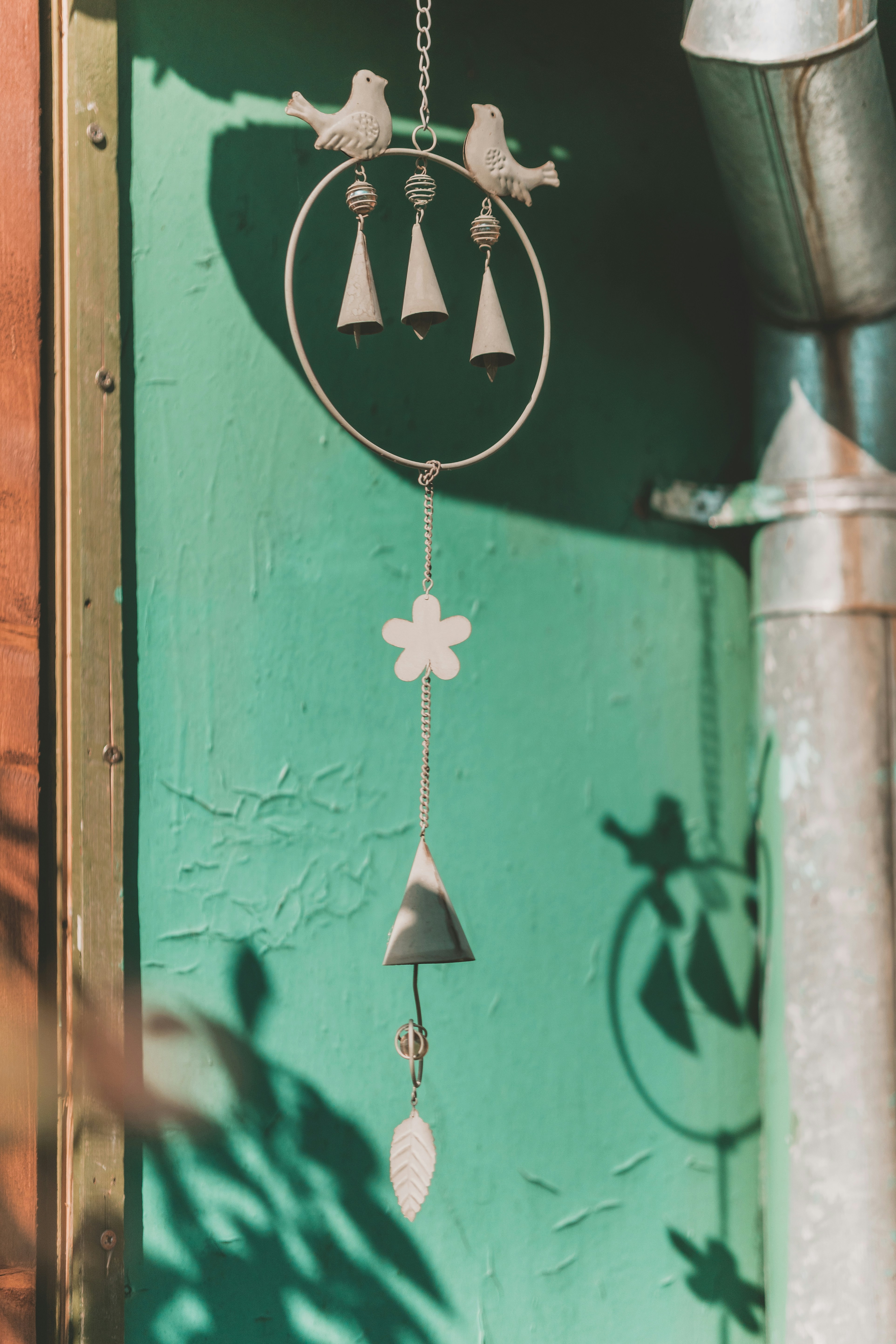 Metallic Wind-Chime Medley Against Teal Wall