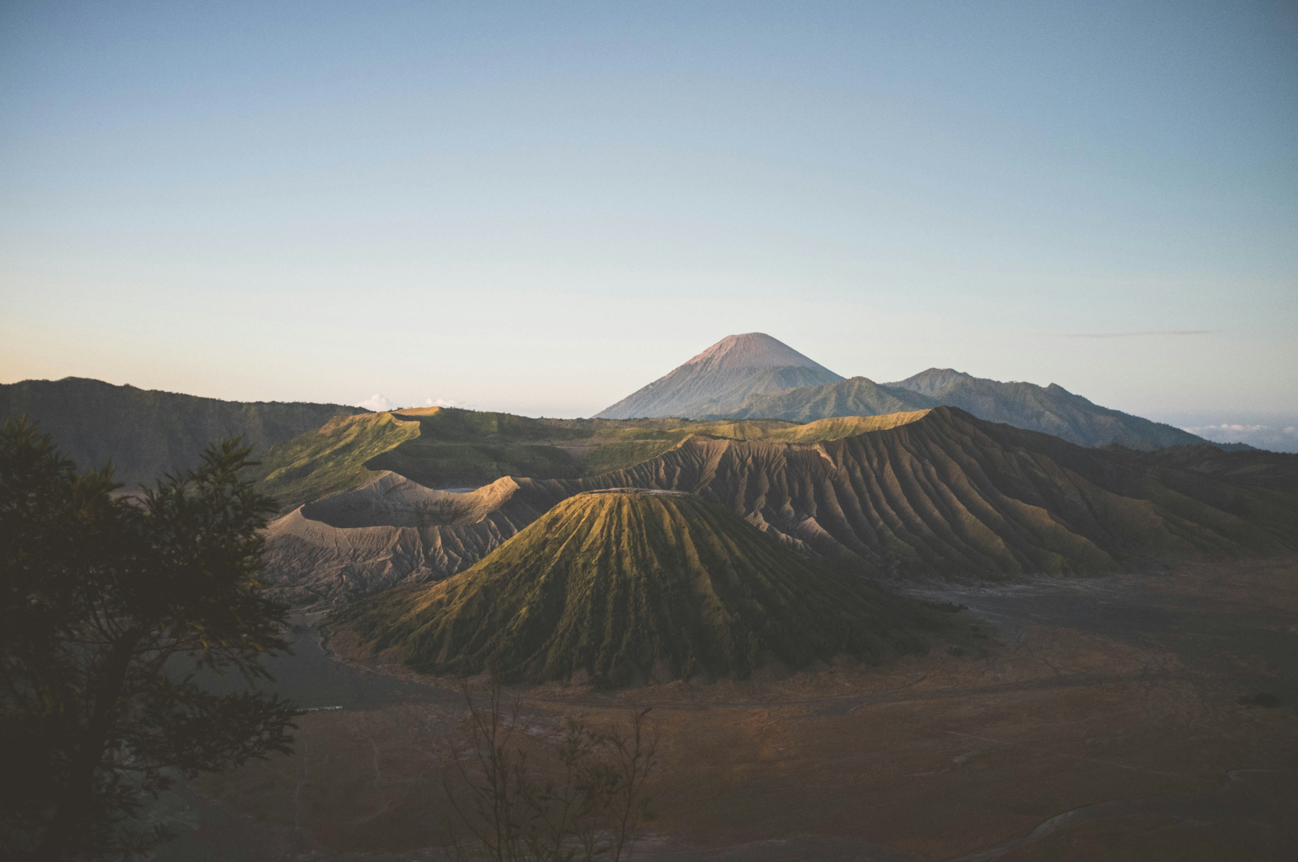 Mount Bromo and surrounding landscape bathed in soft morning light.