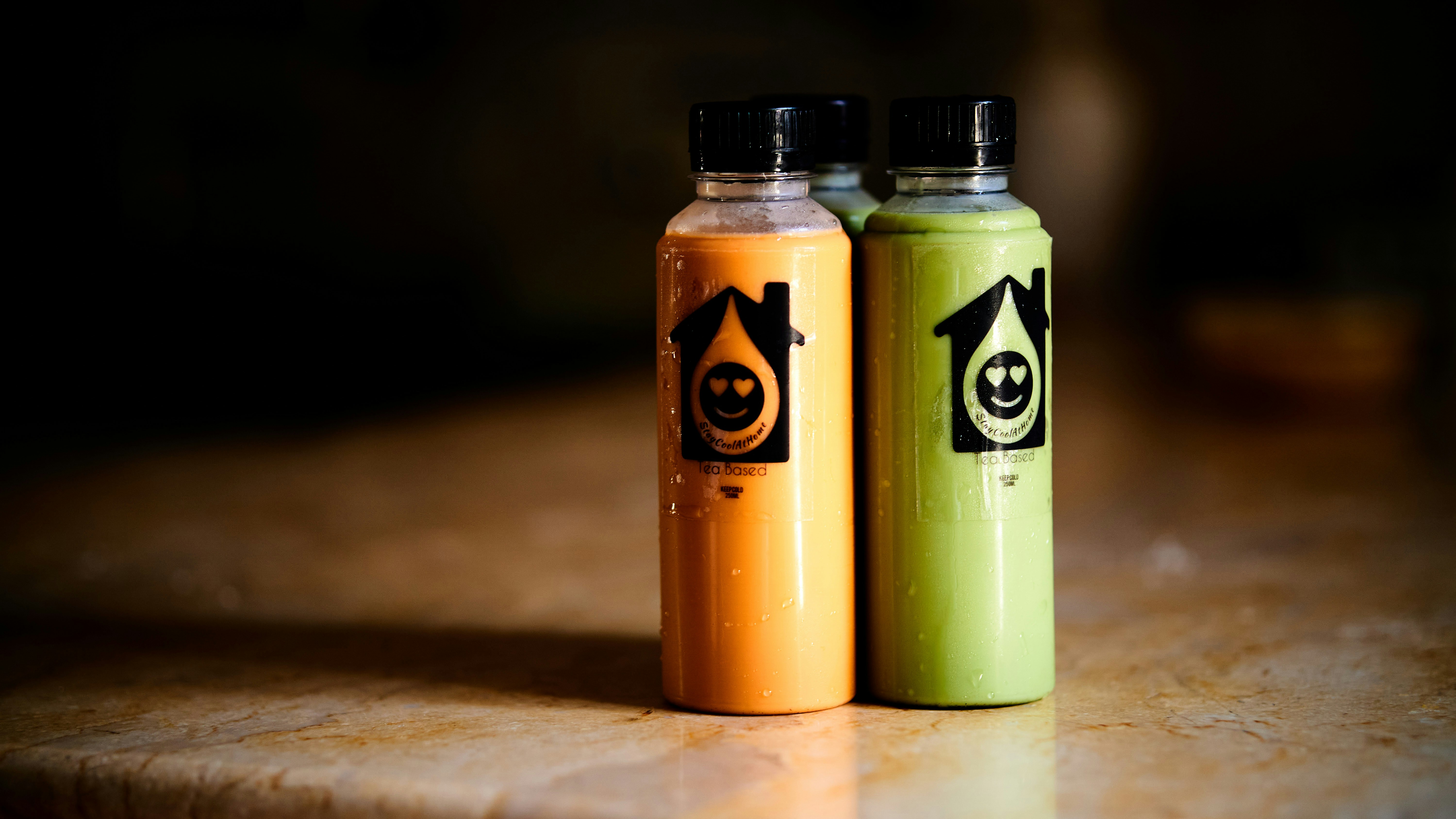 Spotlit Duo: Orange and Olive Paint Bottles on Weathered Wood