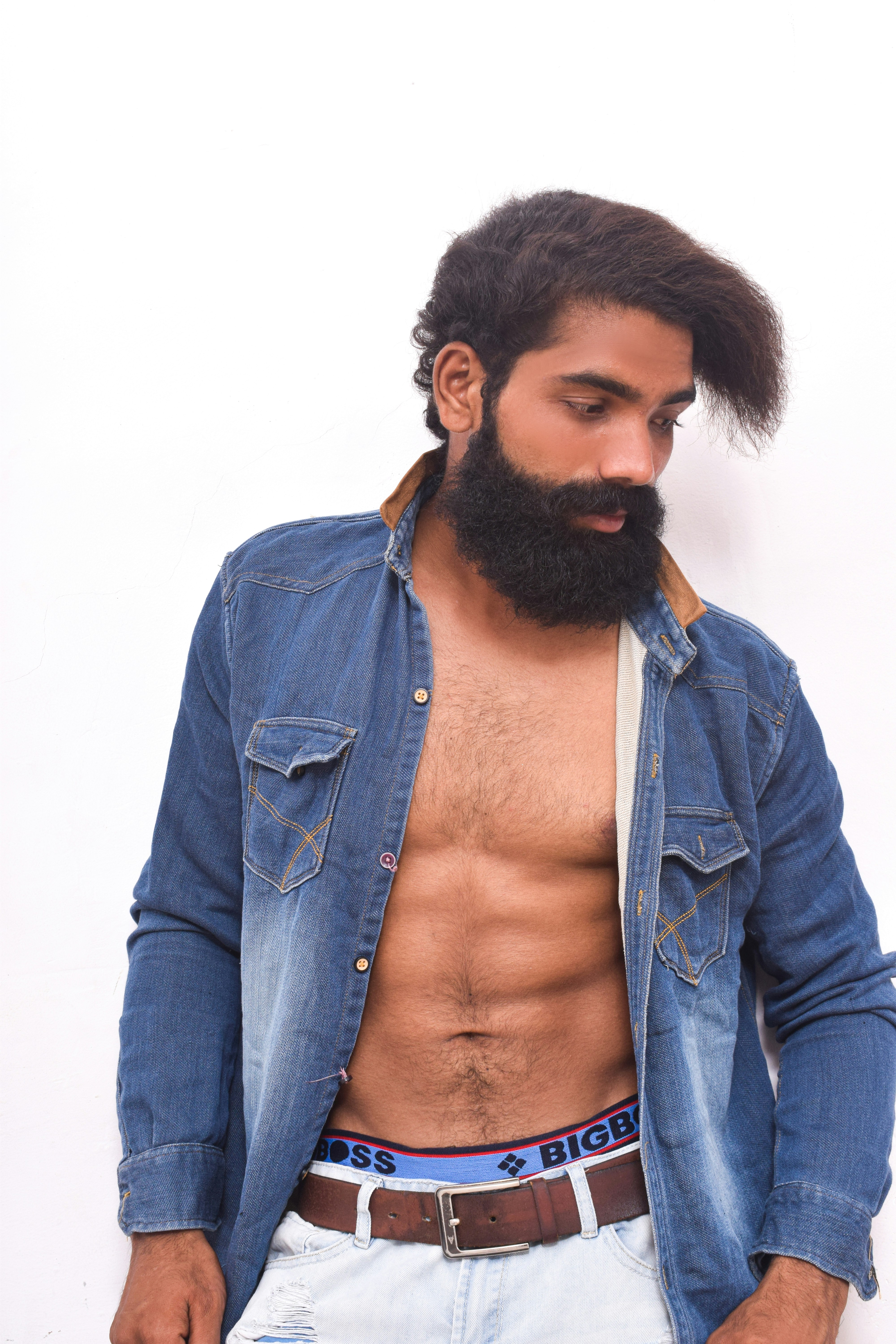 Denim-Drift: A Man with Beard and Bare Chest in Warm Light