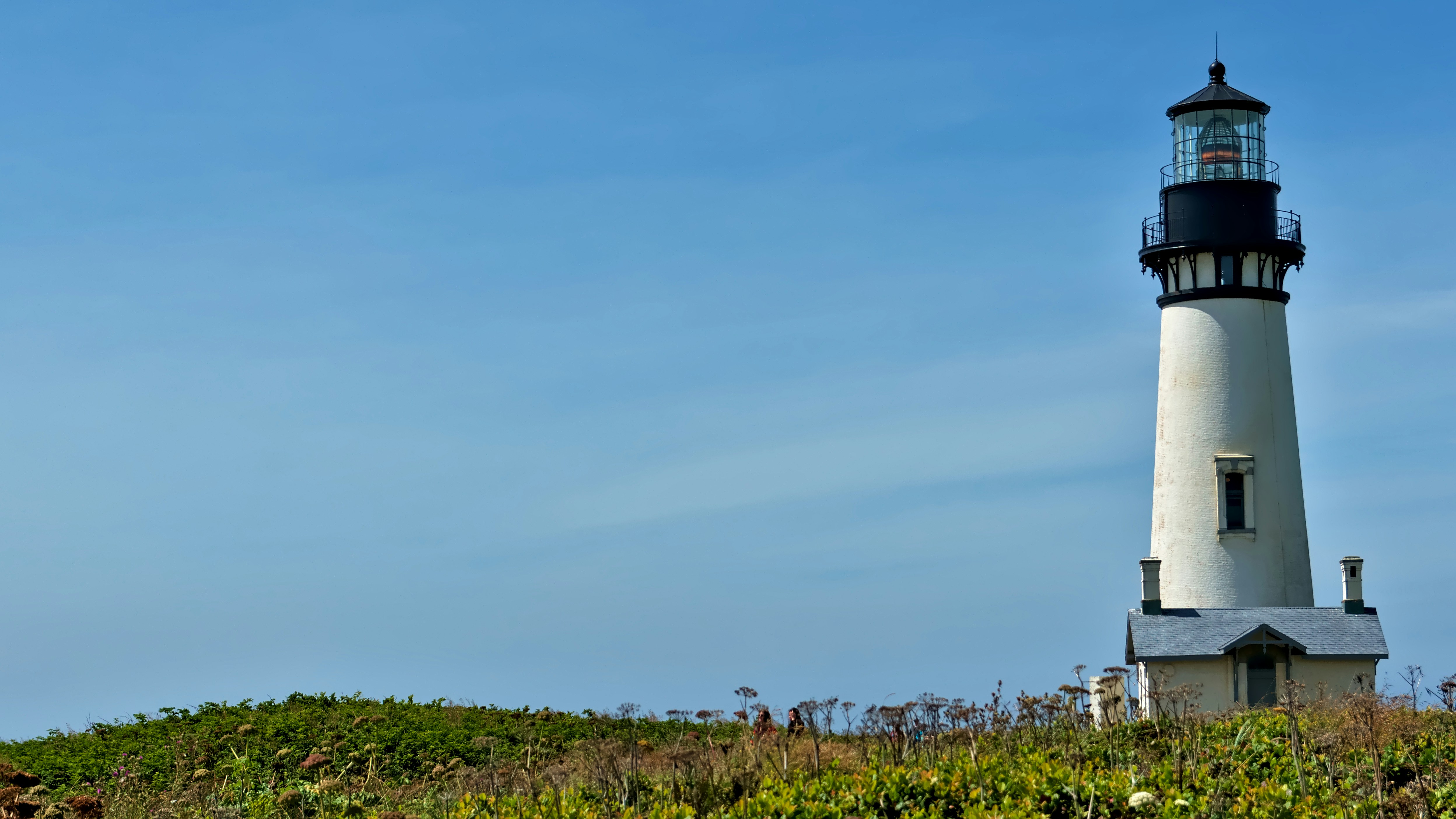 Beacon on the Clifftop: A Seaside Lighthouse Under a Cerulean Sky