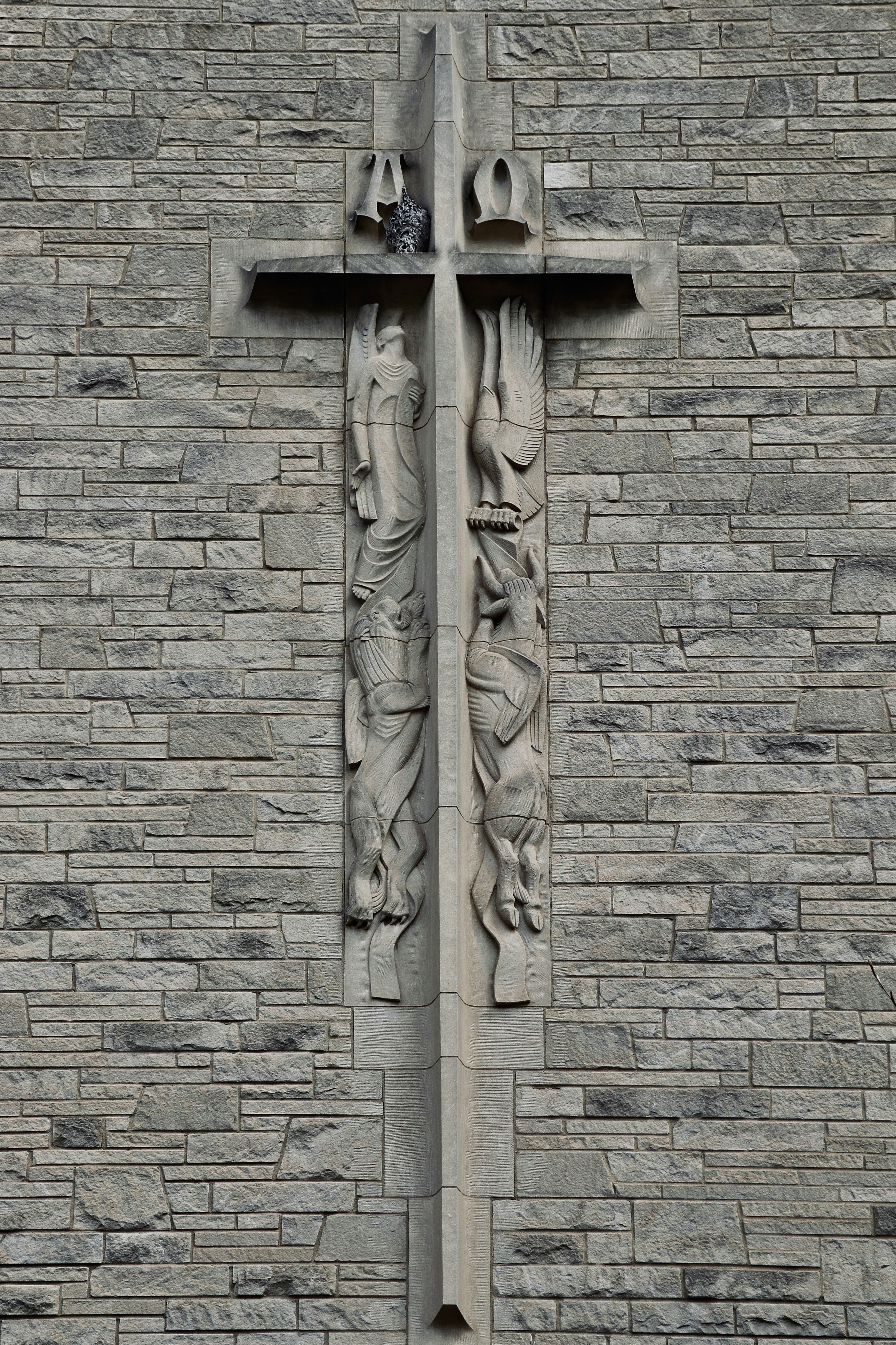 brown wooden cross on brown brick wall