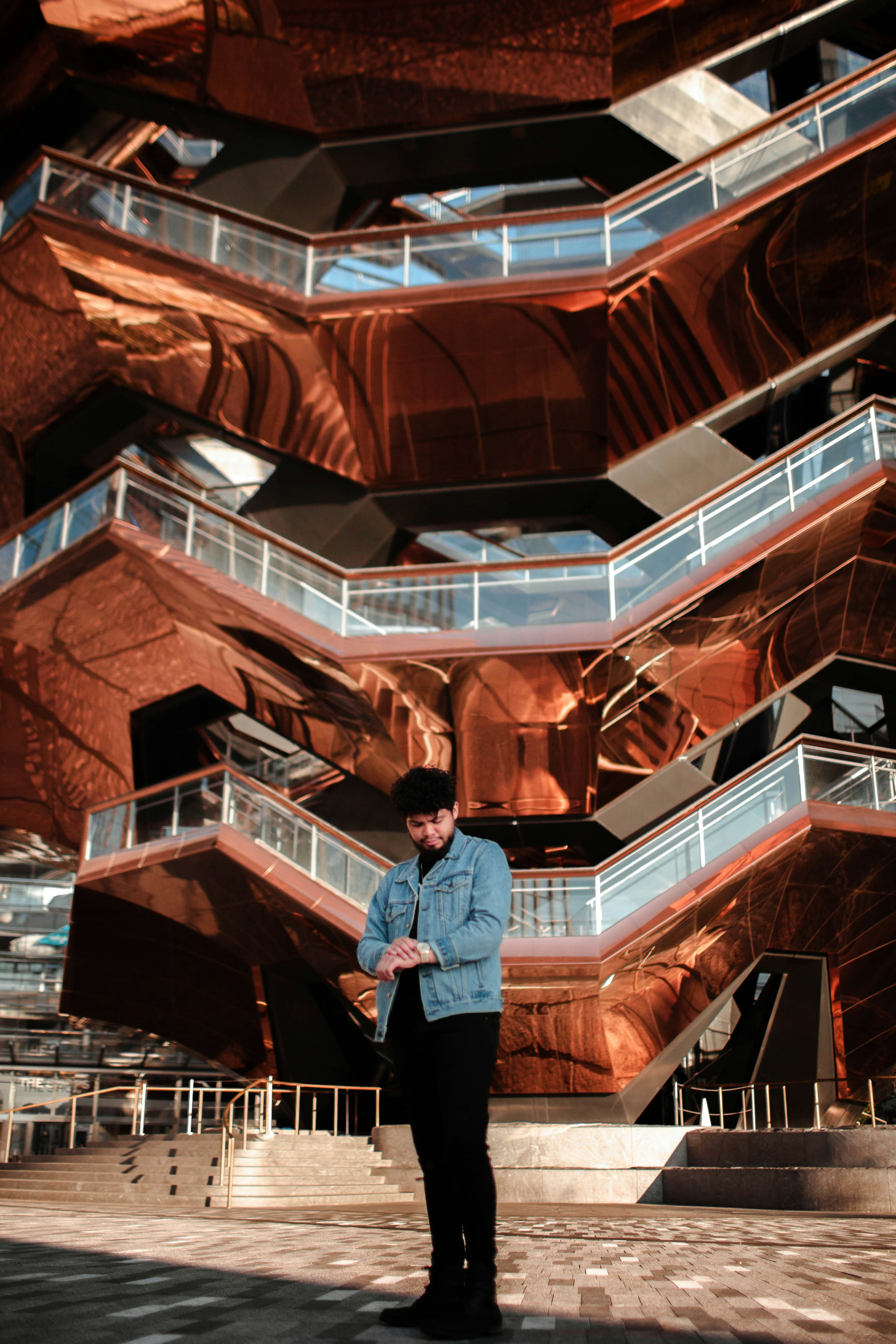 Man in blue dress shirt and black pants standing on brown concrete ...