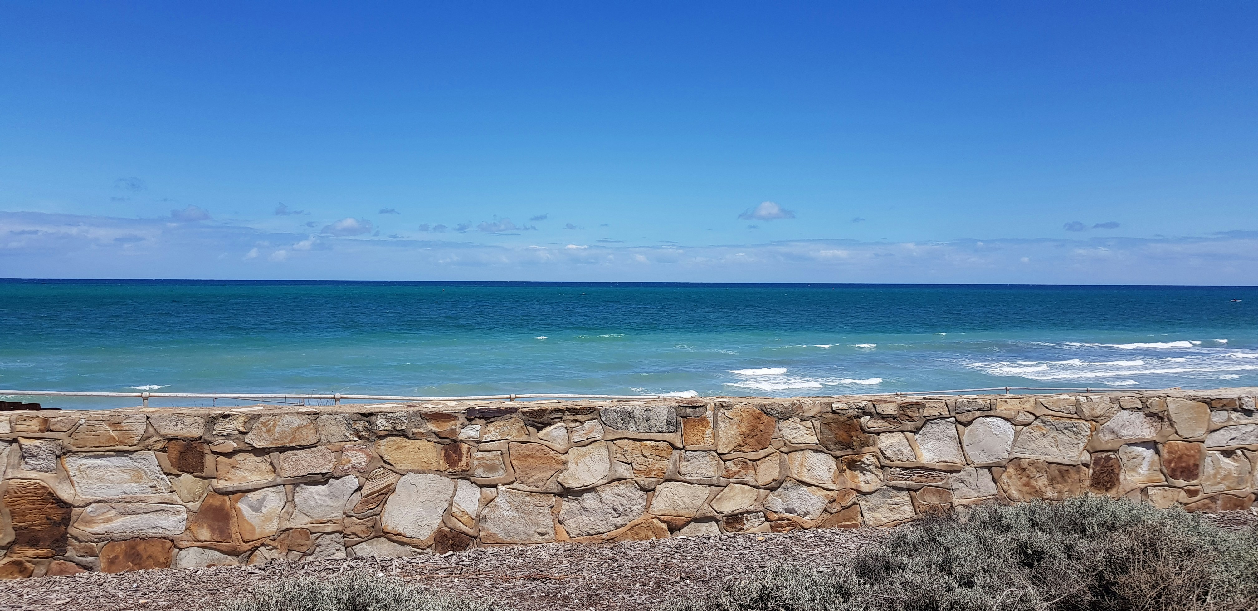 brown and gray rocks near body of water during daytime