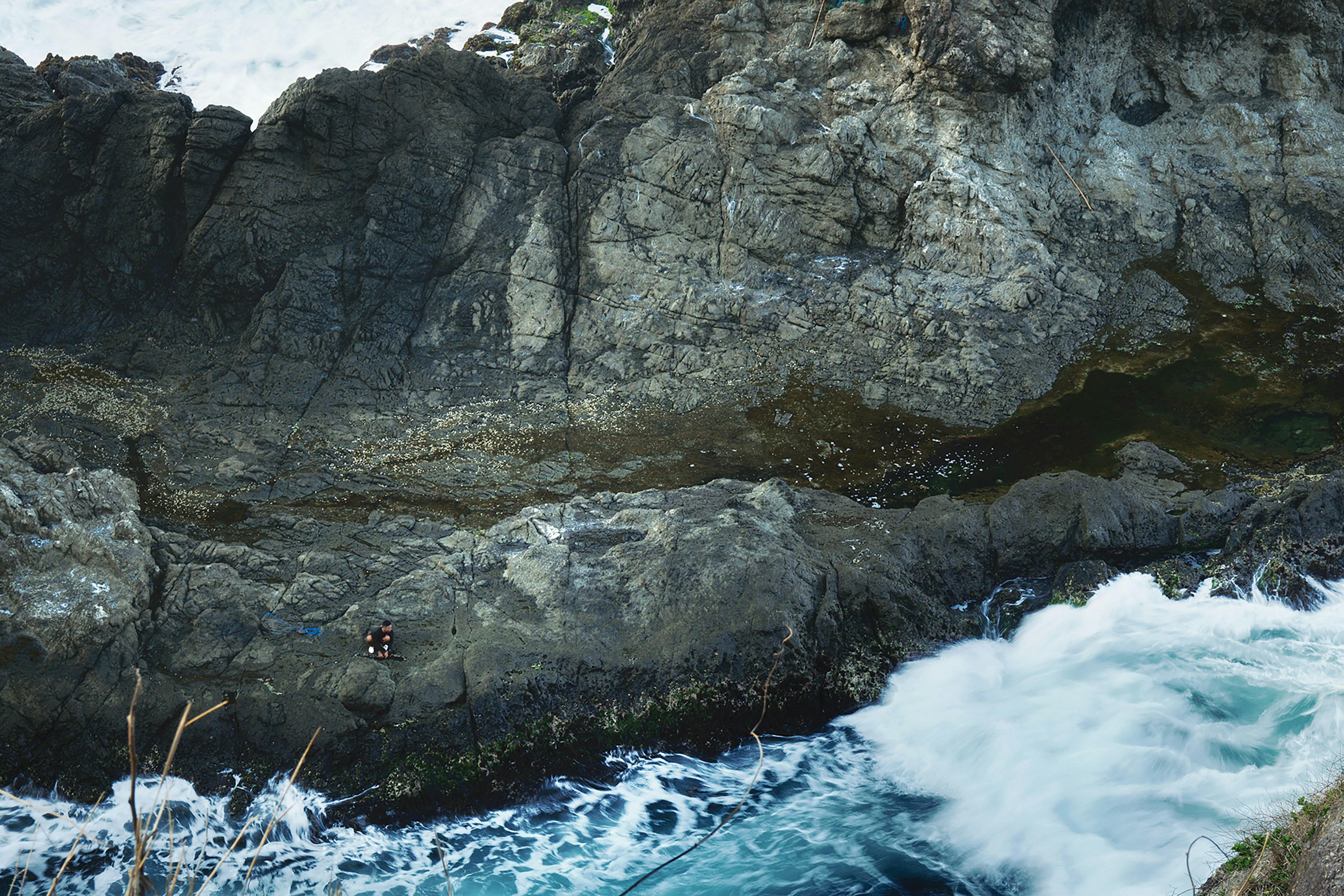Edge of the Tide: A Craggy Sea Cliff Fringed by Whitewash