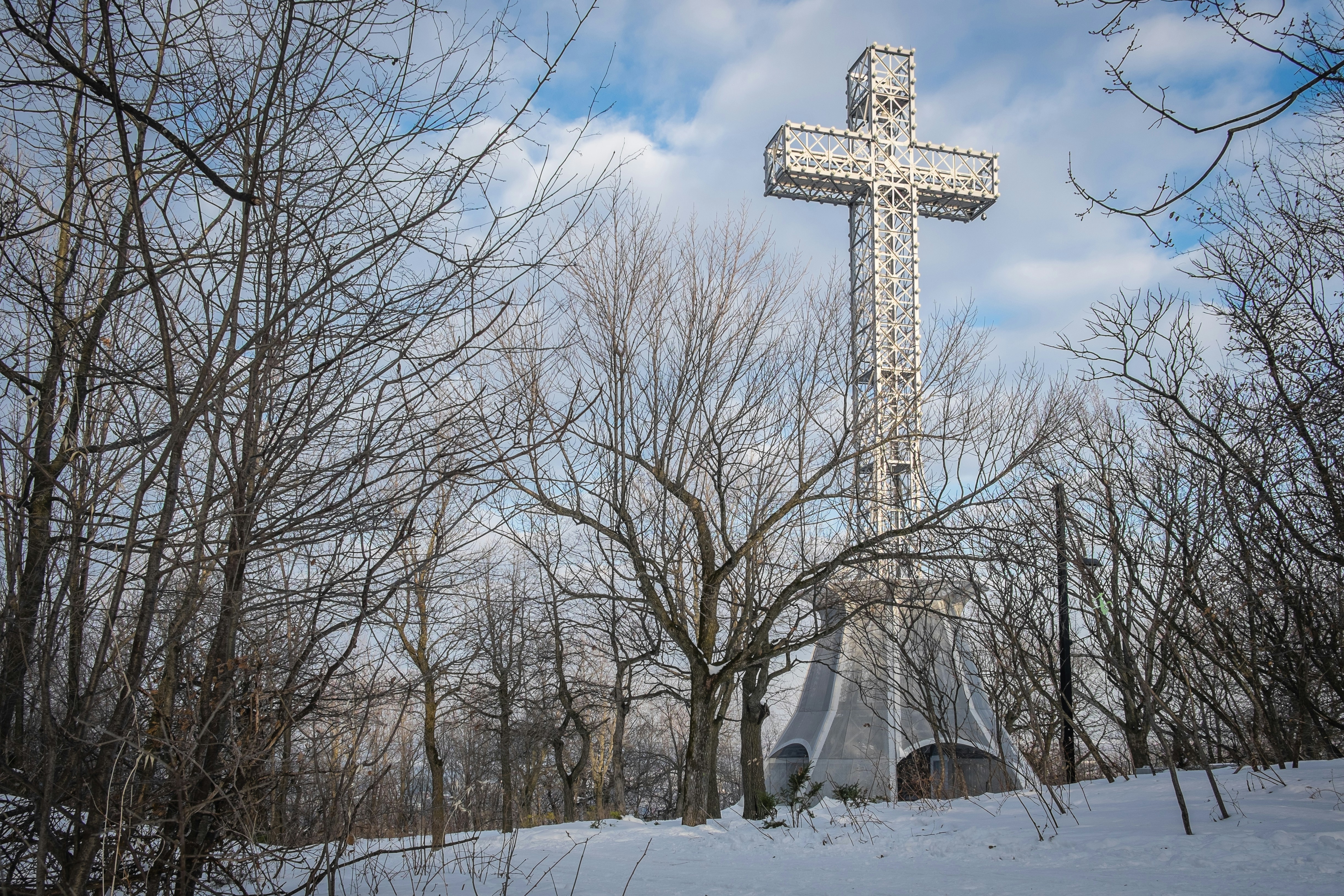 Snowlit Cross Tower Surrounded by Quiet Winter TreesPierre Jarry