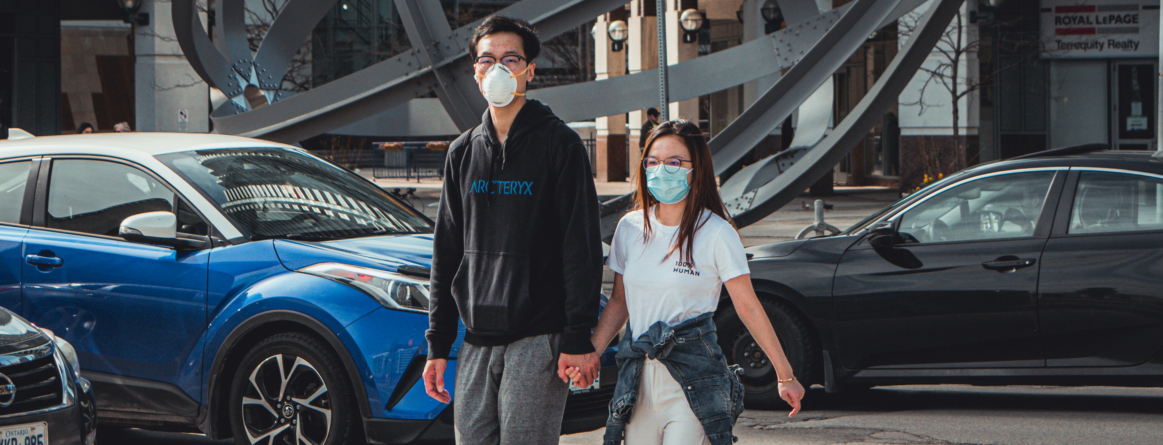 Masked Walk: A Couple Crossing in an Urban Gallery of Steel