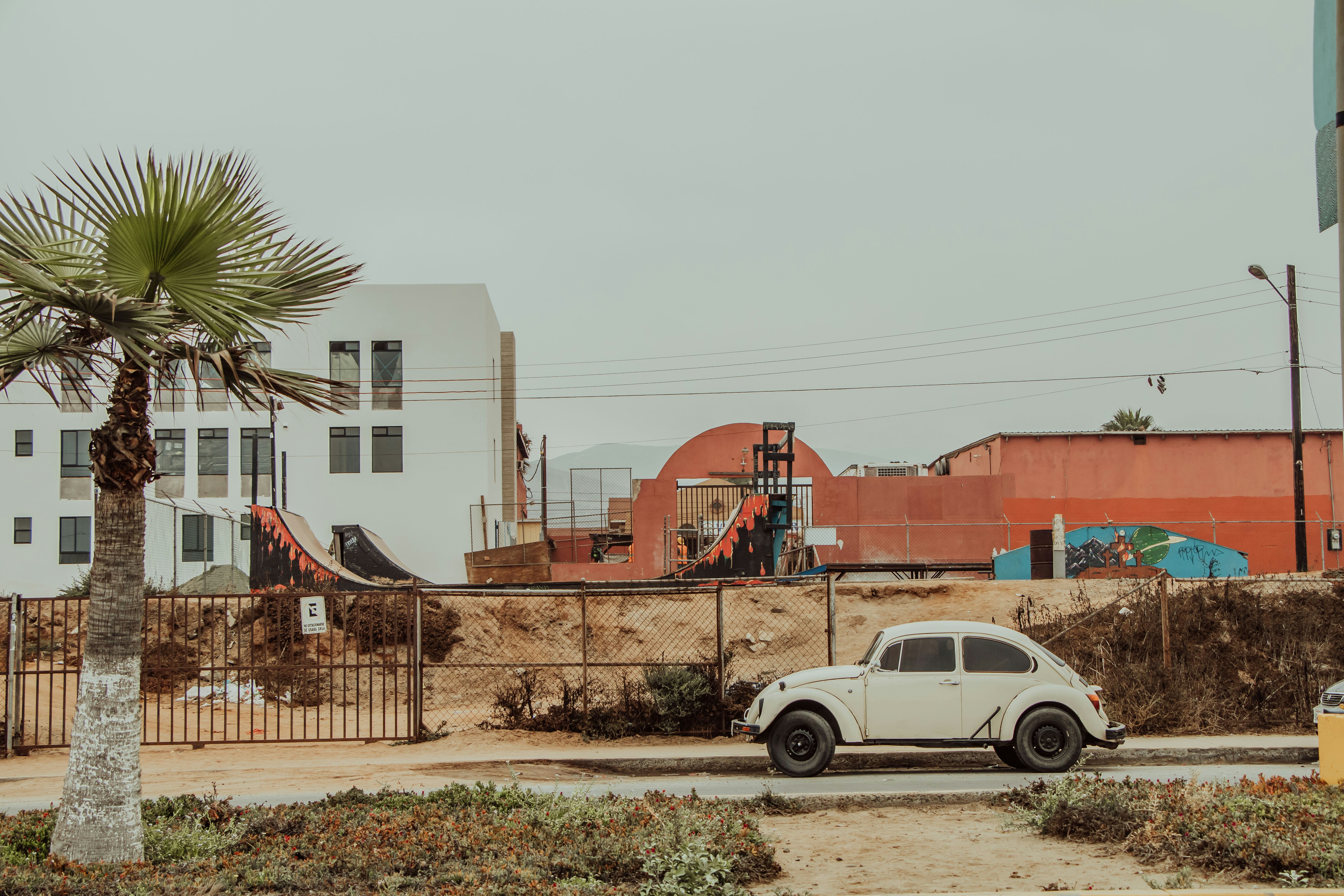 white crew cab pickup truck parked near brown concrete building during daytime