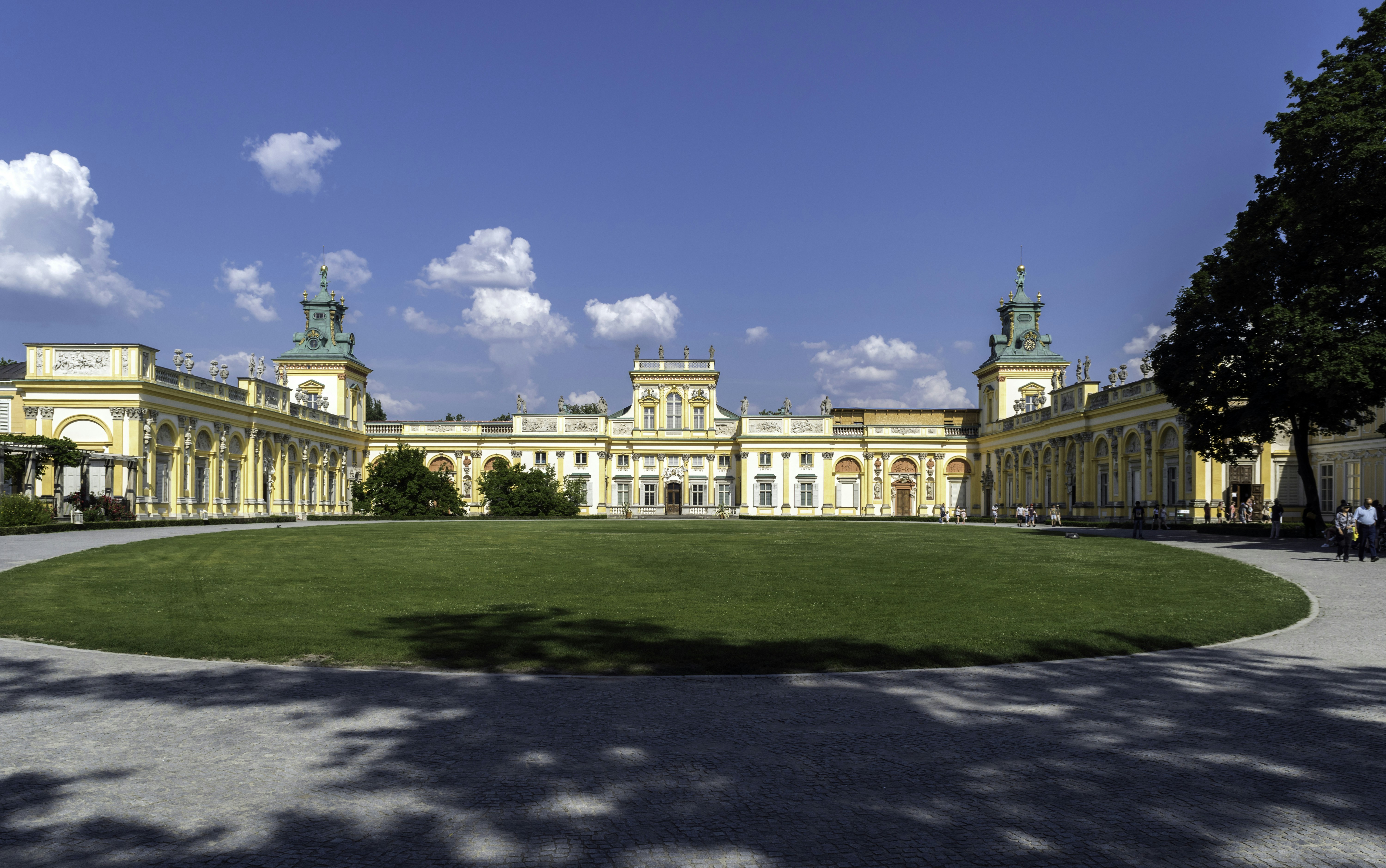 Expansive palace façade with symmetrical towers under a clear blue sky.