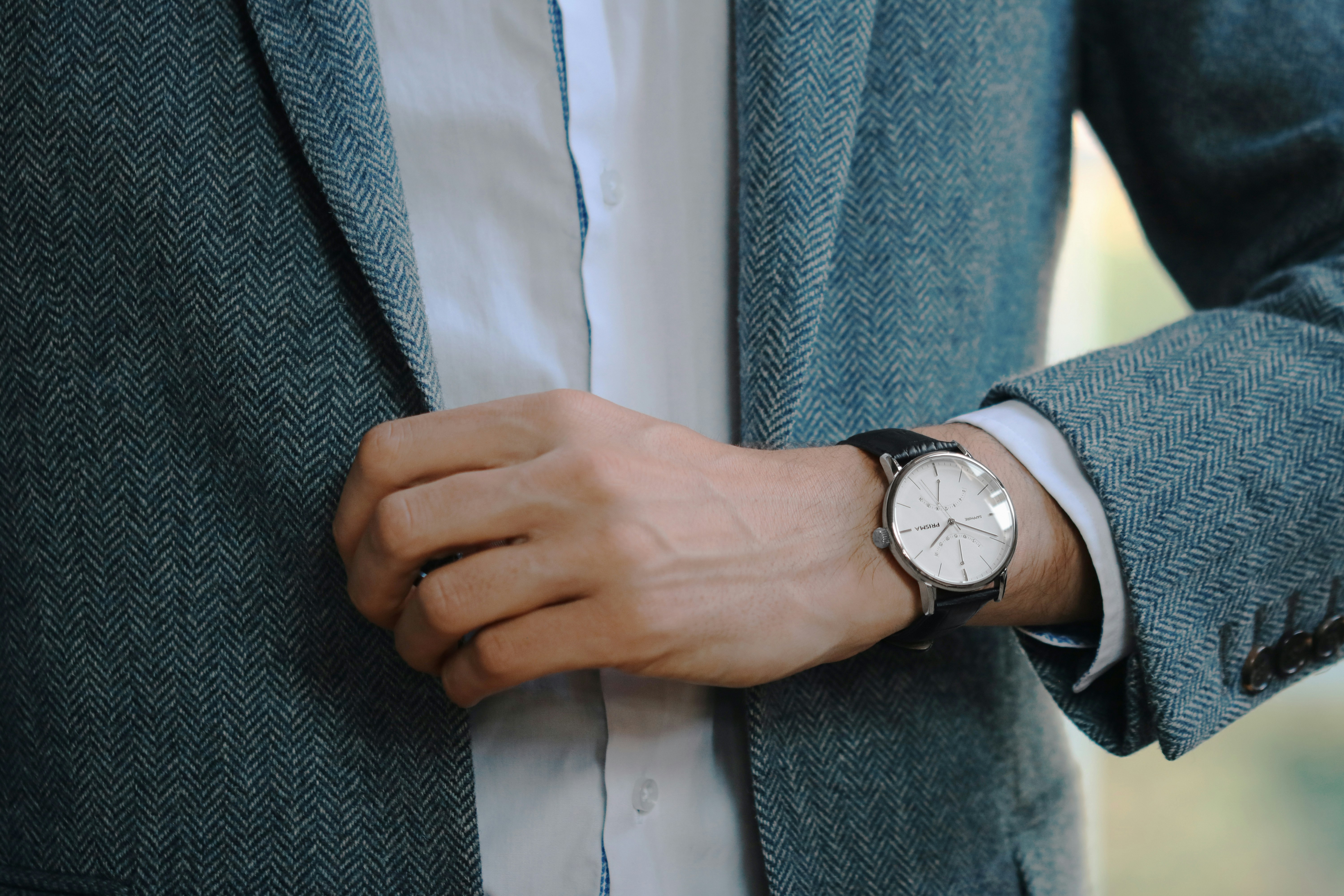 Man in white dress shirt and gray vest wearing silver round analog ...