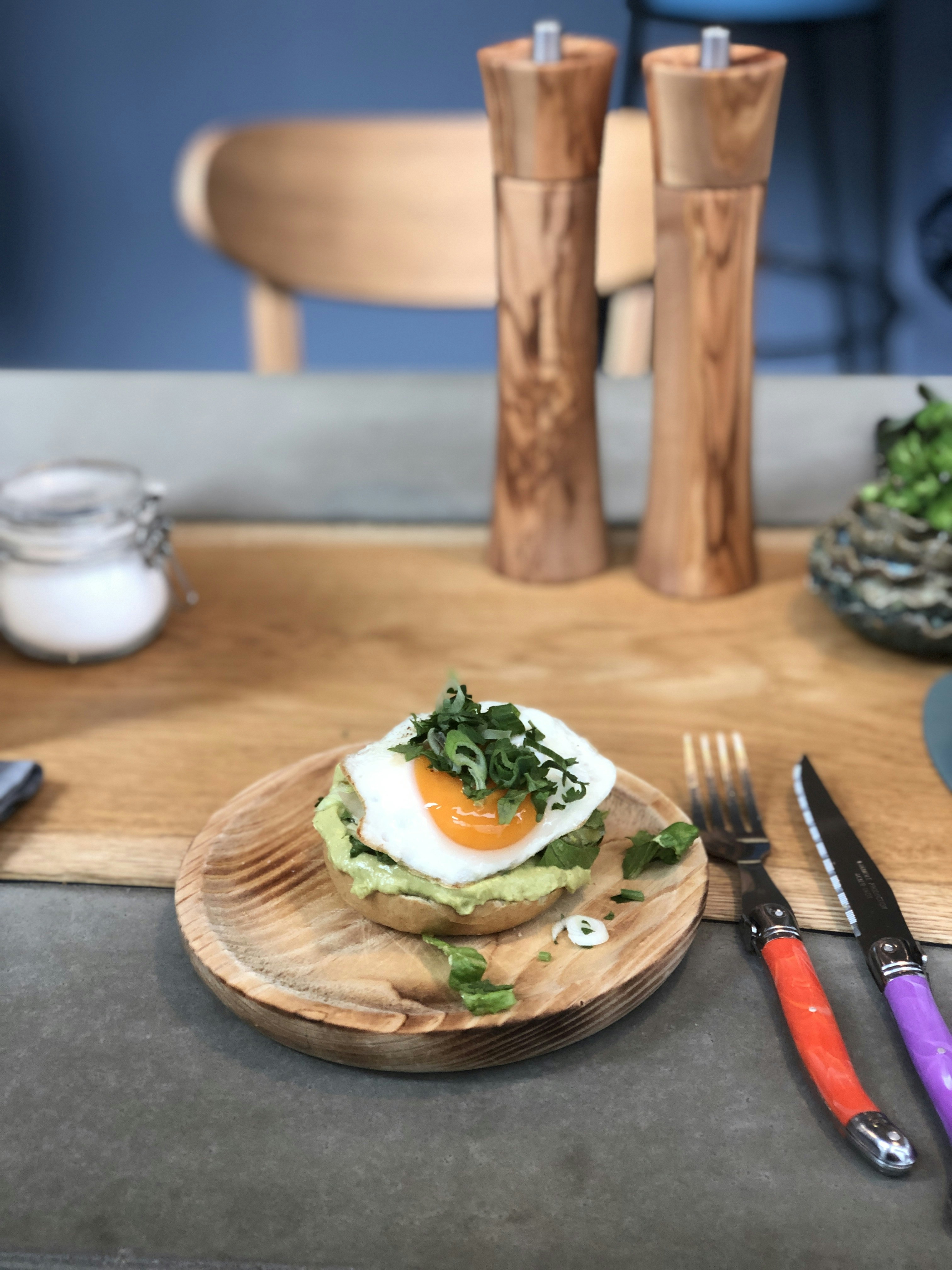 Sunny Egg on Avocado Stack: Gourmet Breakfast at the Wooden Table