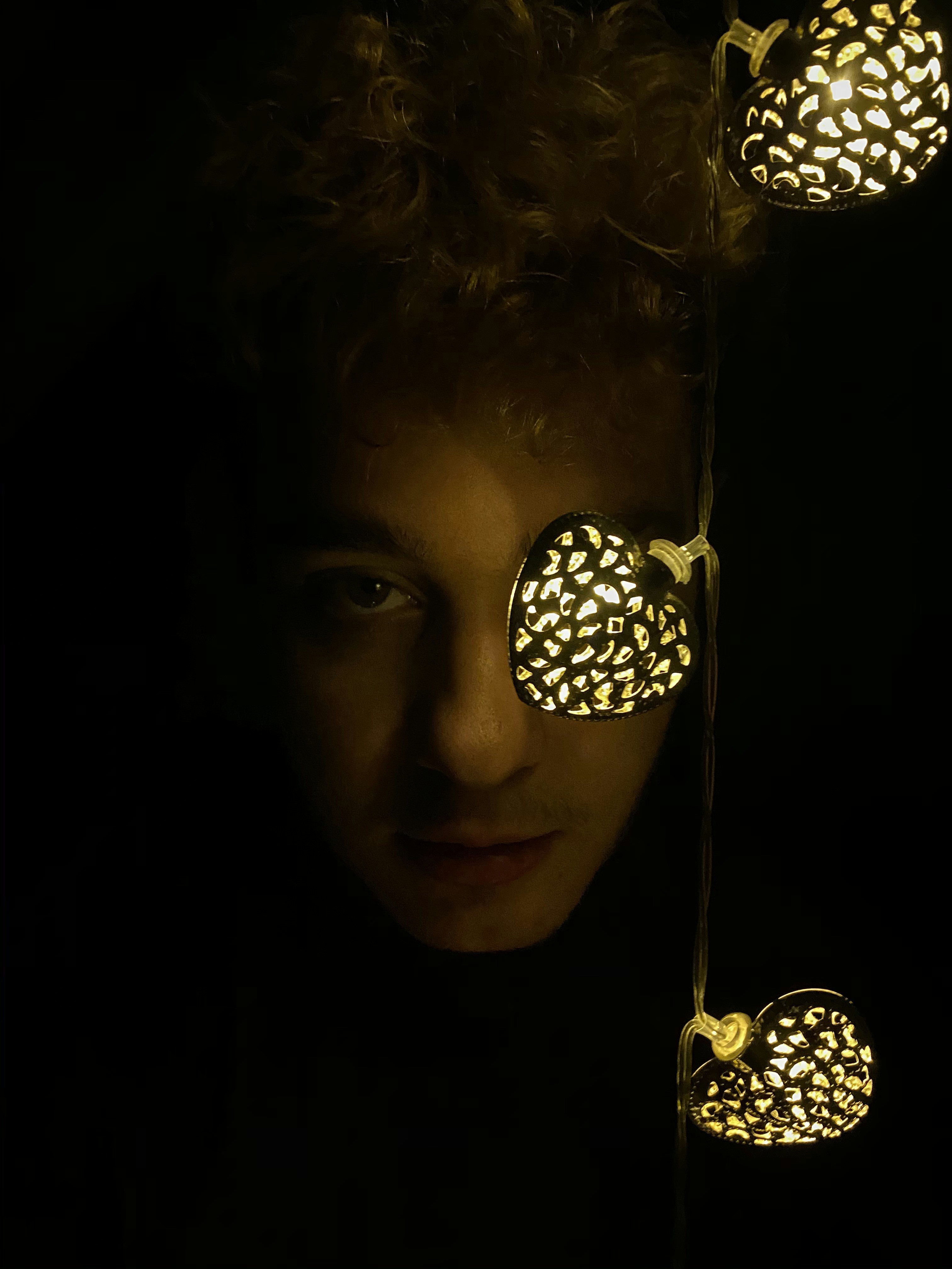 Heartlight Portrait: A Face Emerges Amid Warm, Dim String Lights