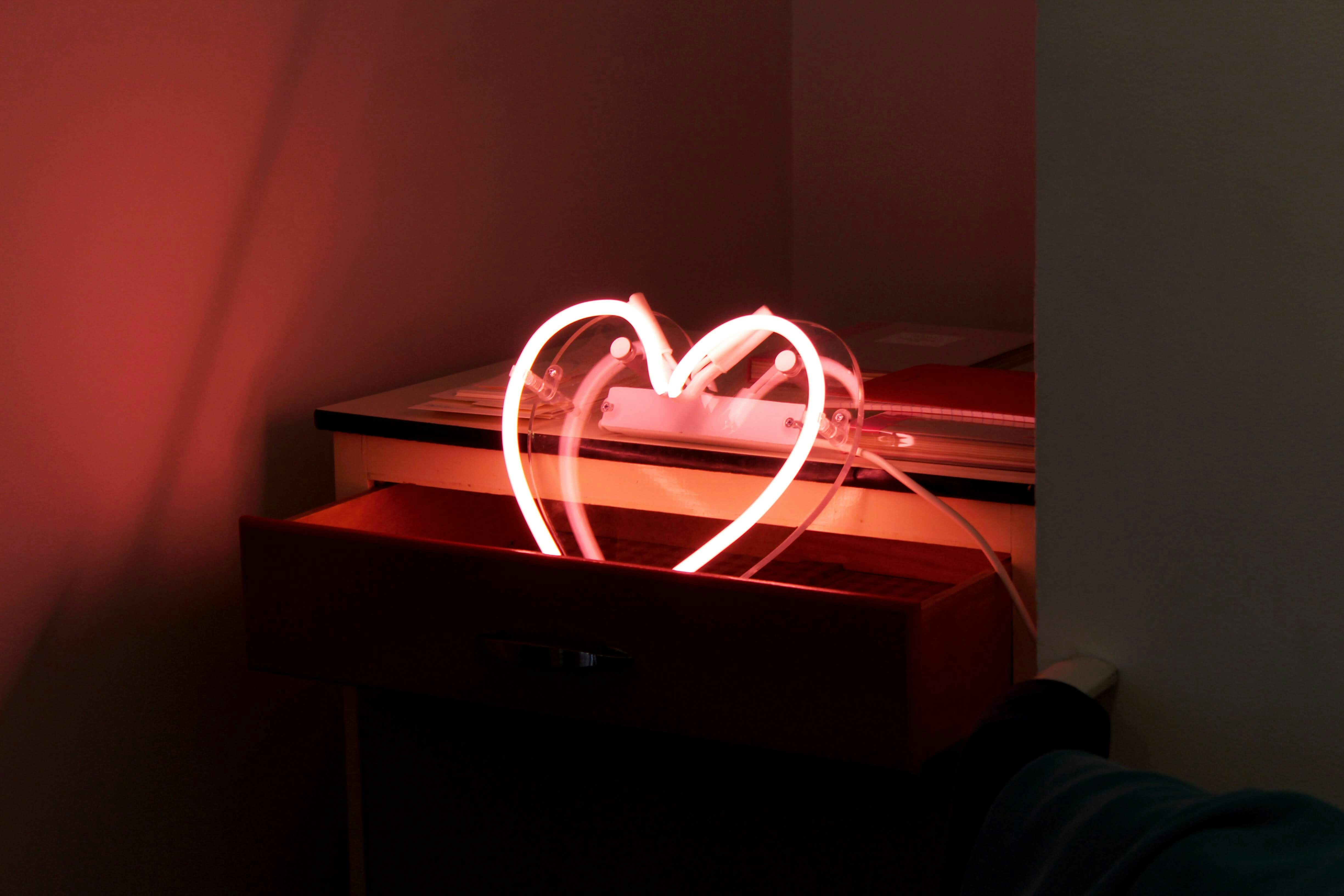 Heartlight on a Quiet Nightstand: Neon Glow in a Dark Room
