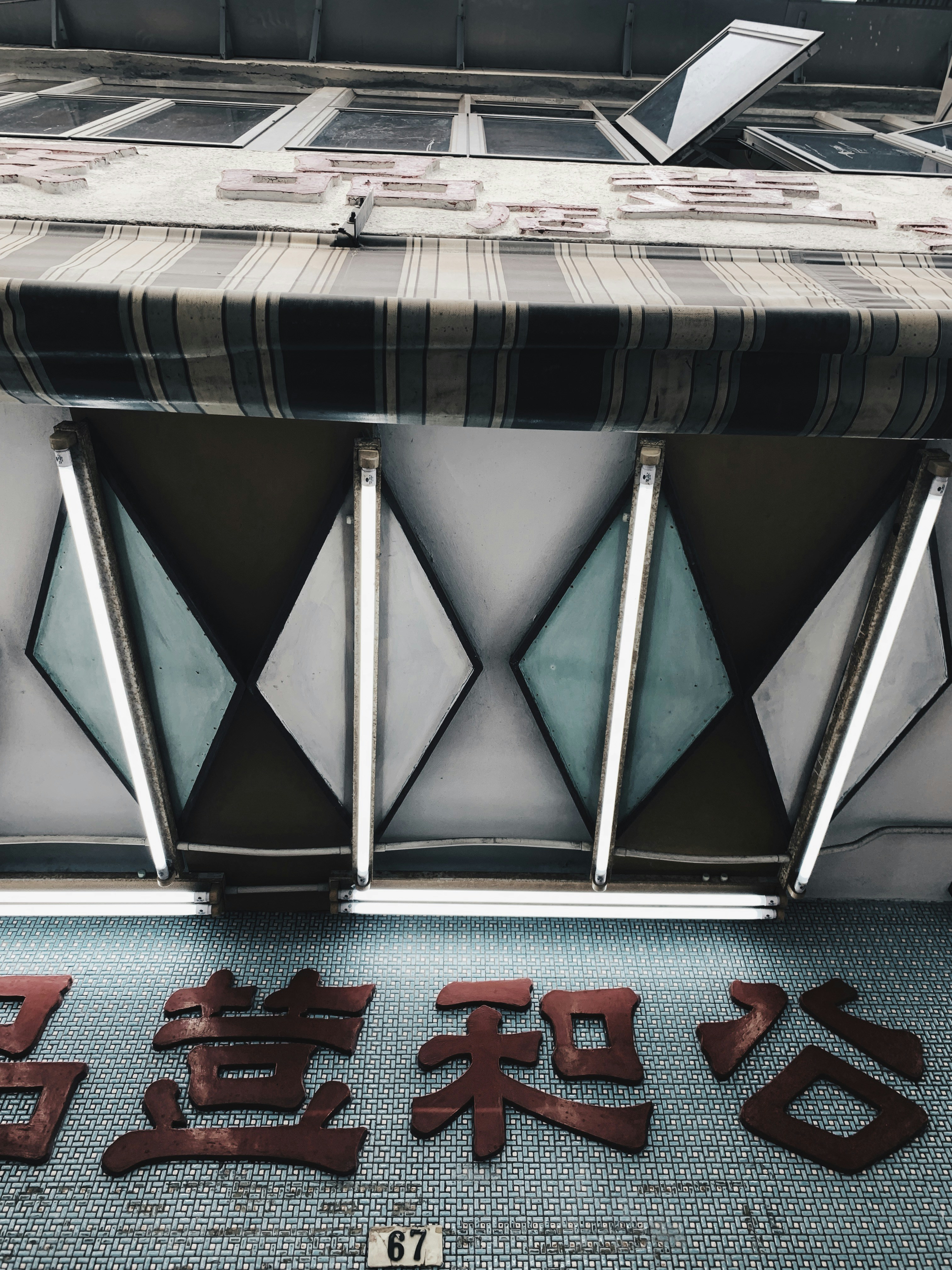 Diamond-Grid Facade Beneath a Striped Canopy