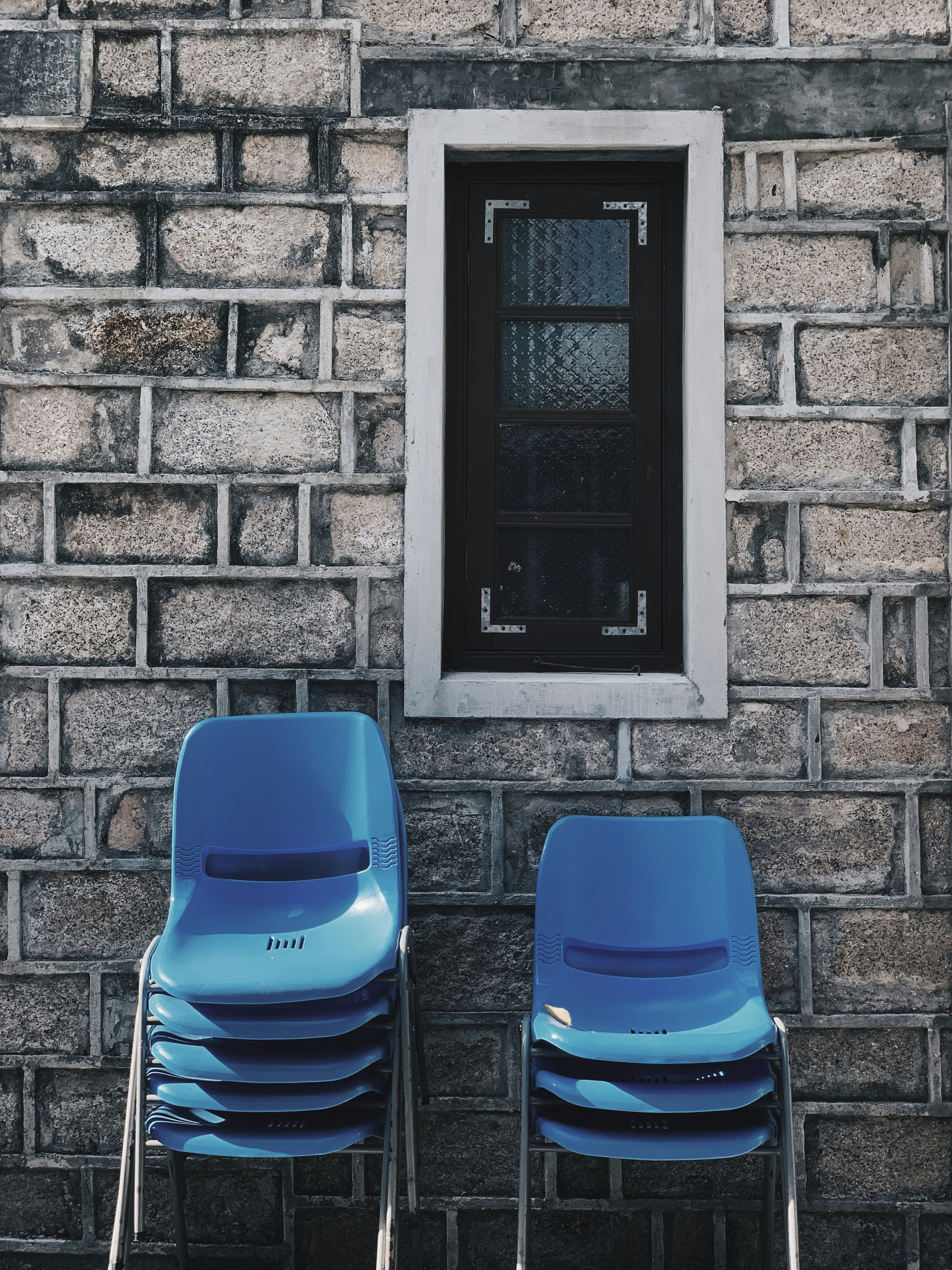 blue plastic chair beside window