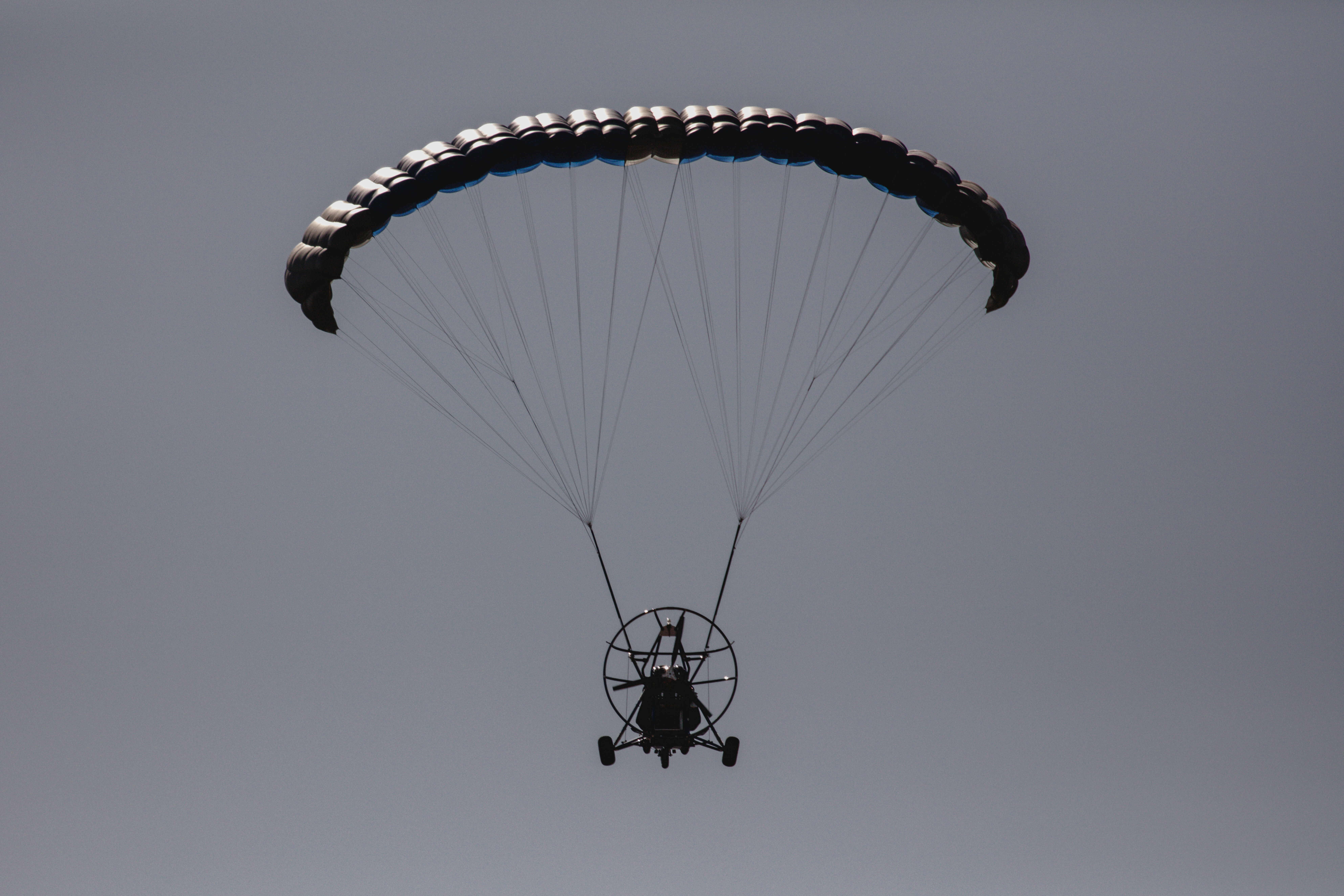 Midair Parachute Runway: A Solo Pilot in Silhouette Against the Sky