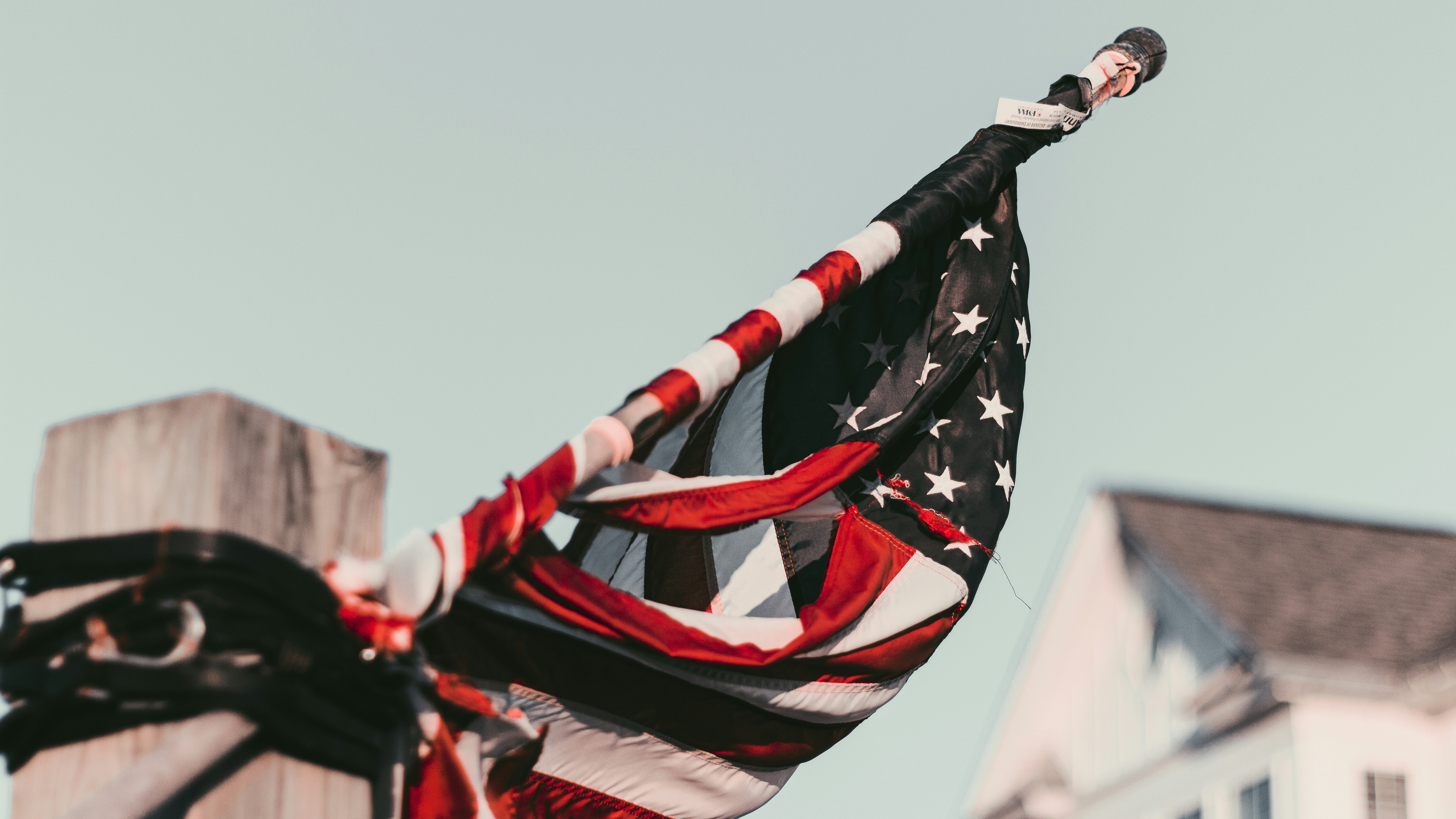 American flag fluttering gracefully against a clear sky, showcasing its vibrant colors and intricate details.
