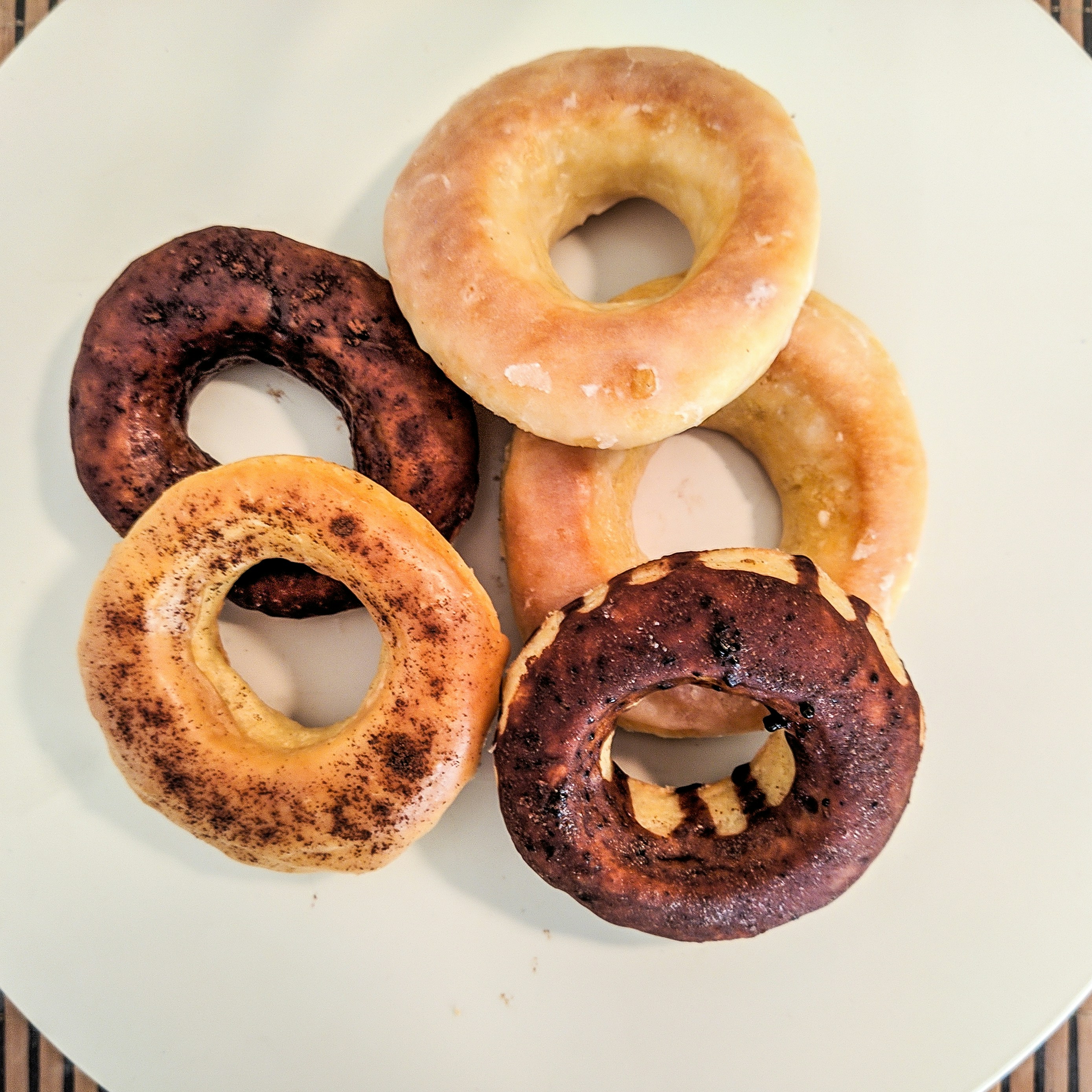 Assorted homemade donuts arranged on a white plate.